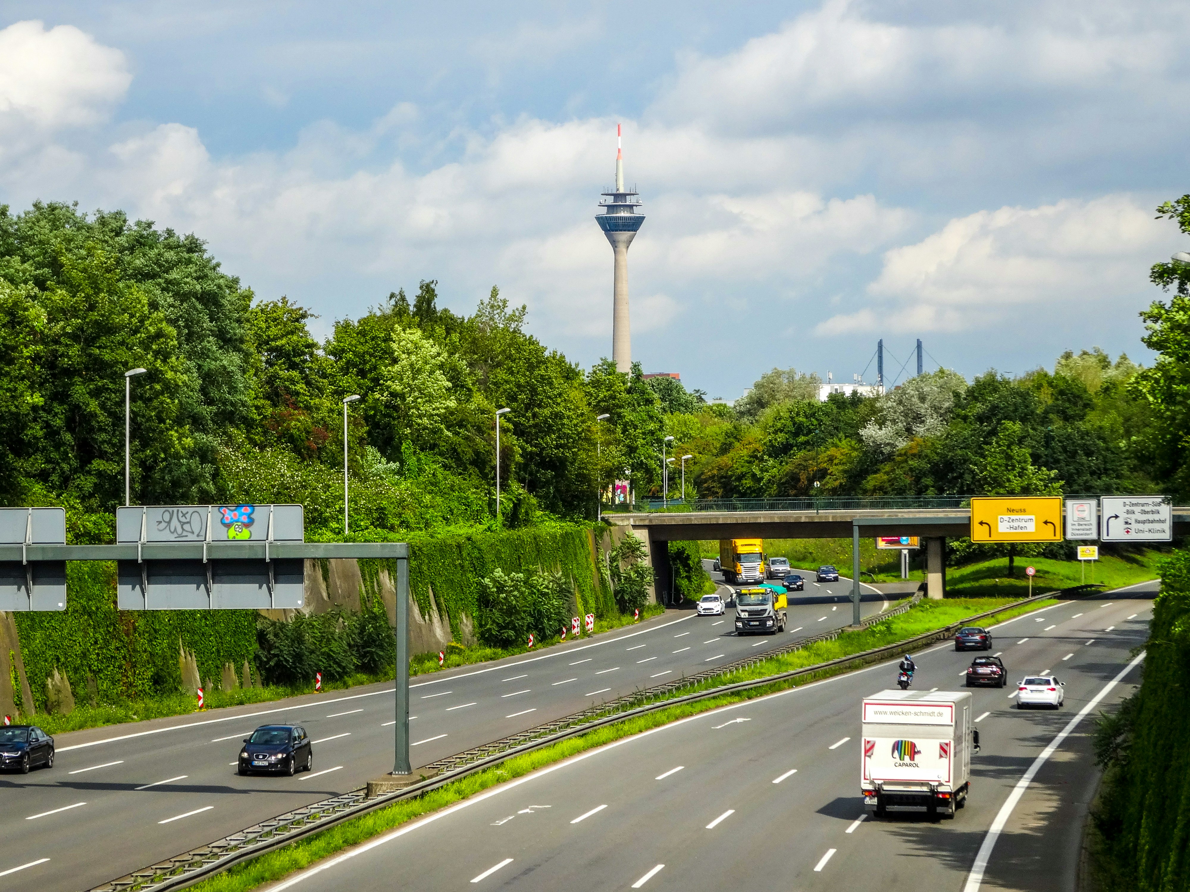 Cars driving on a highway with a tower in background