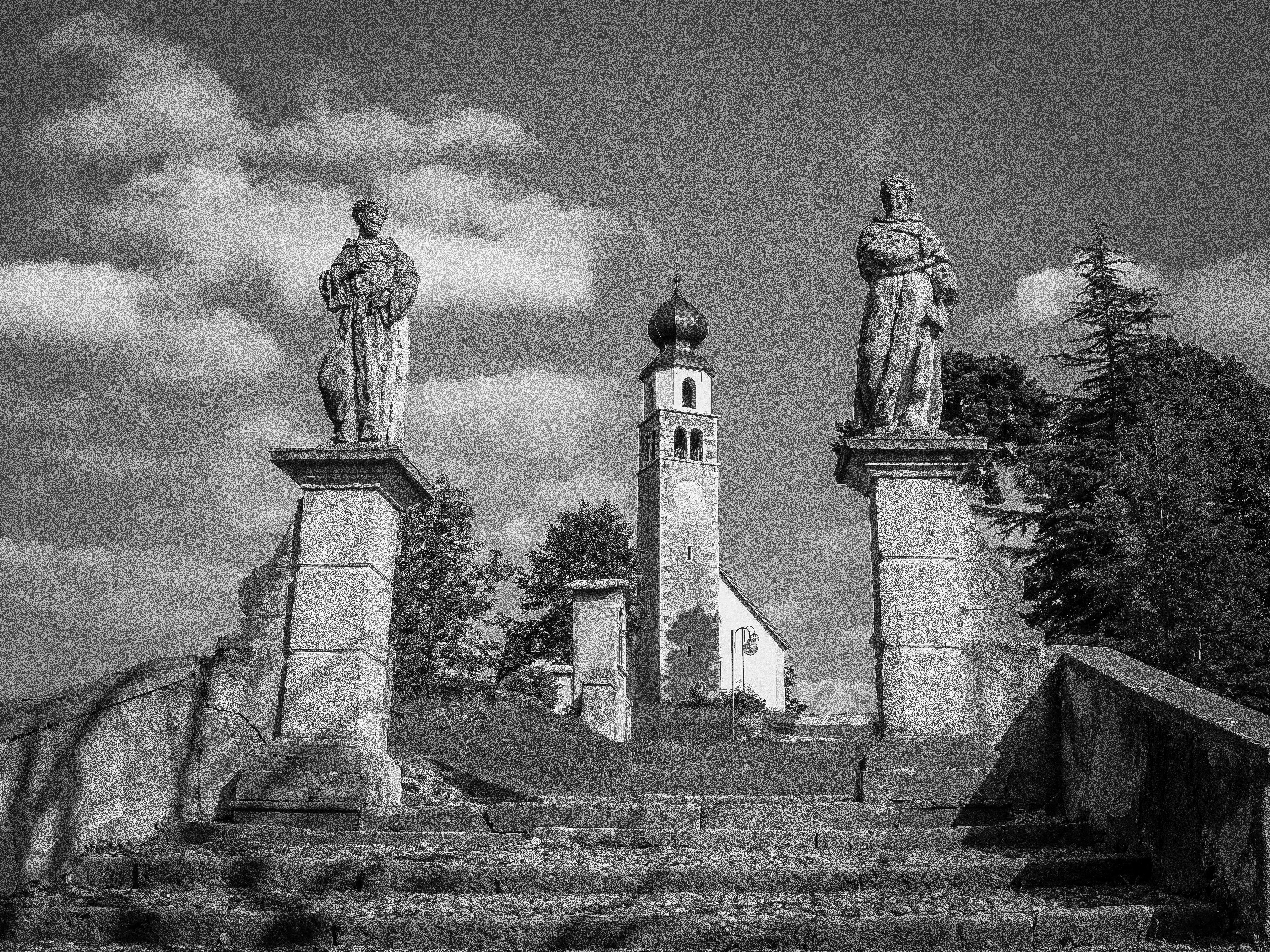 Stone Gate: Statues Framing a Quiet Chapel