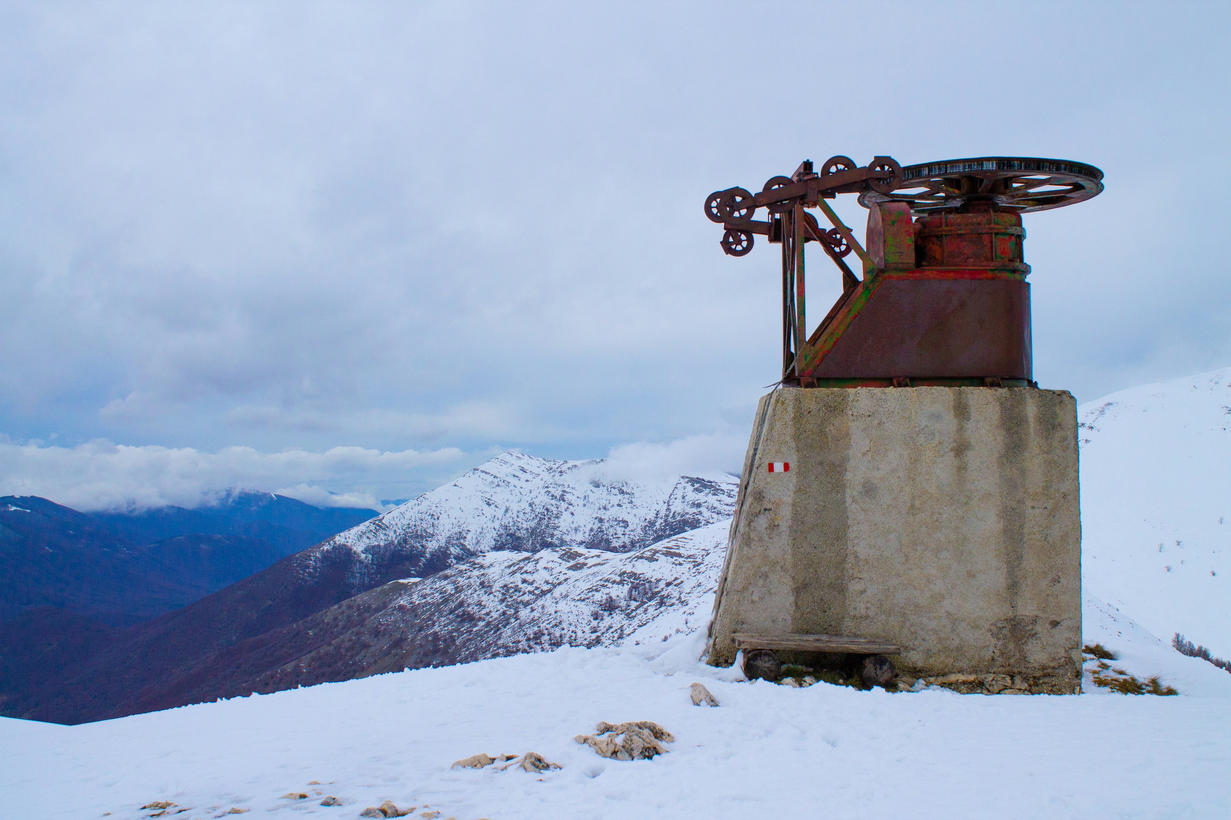 Rusted Ski Lift Engine Amid Snow-Covered Ridge