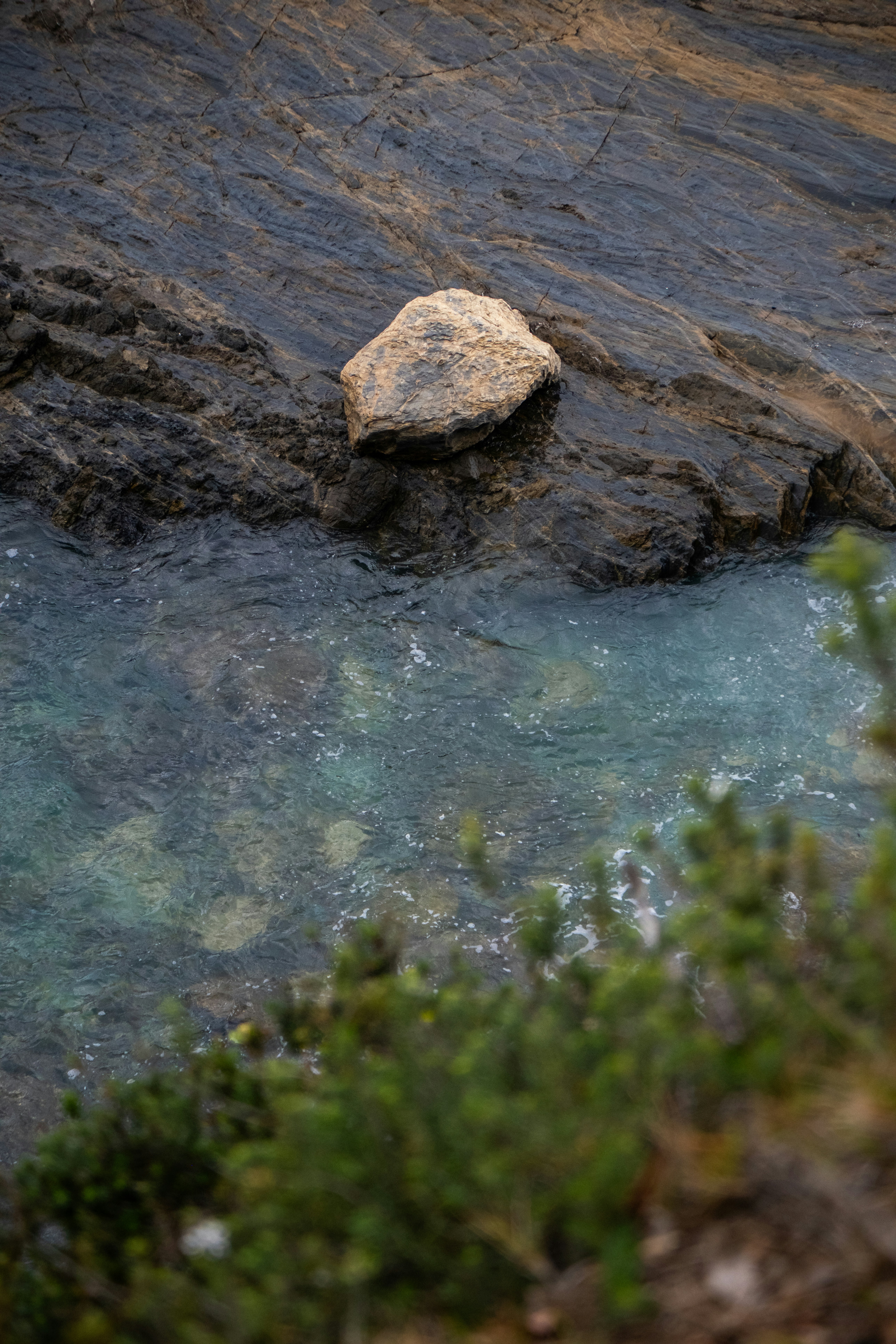 A Quiet Verge: Sunlit Rock Reaching Into Turquoise Tide