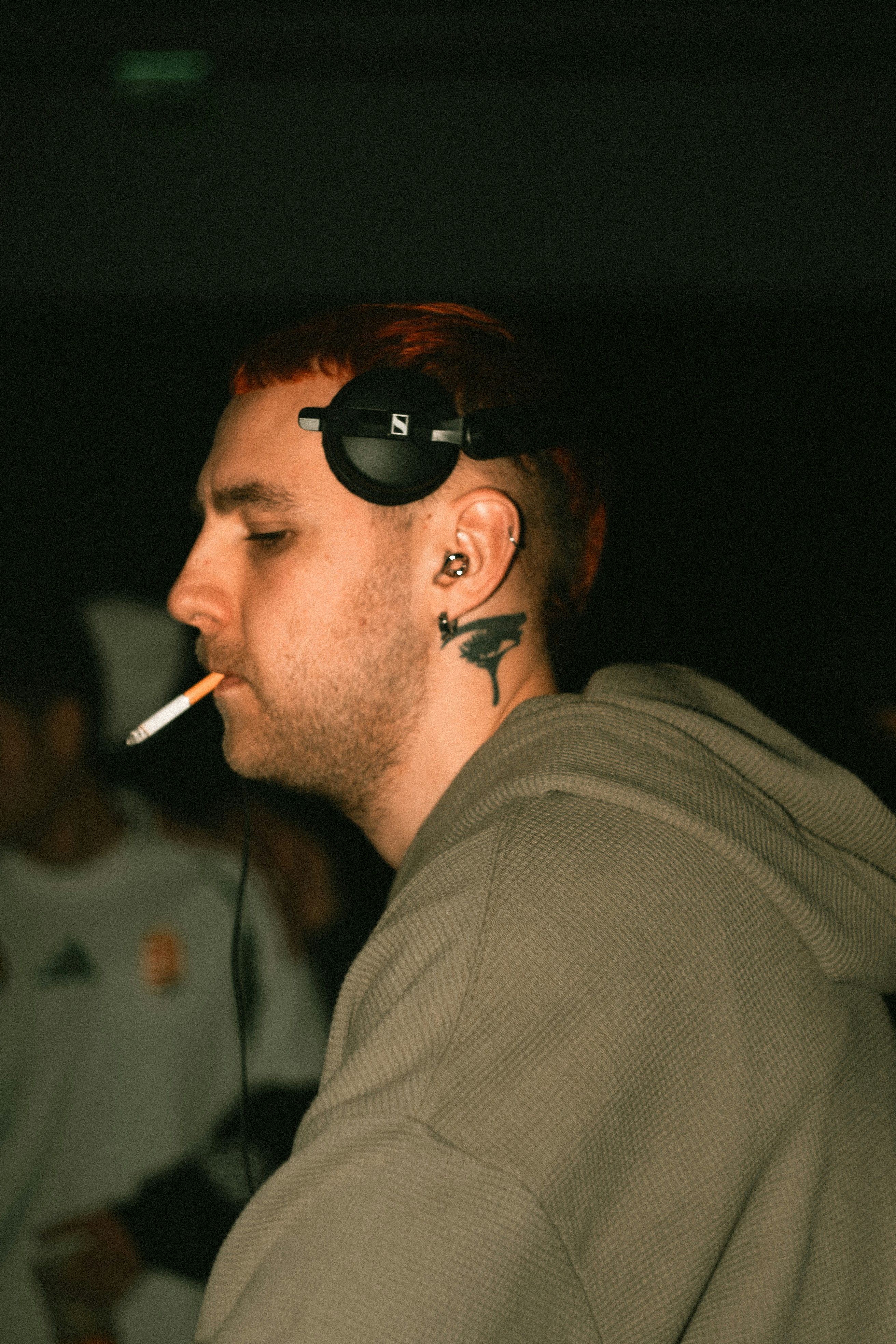 Cigarette glow and headphones: a night portrait in the crowd