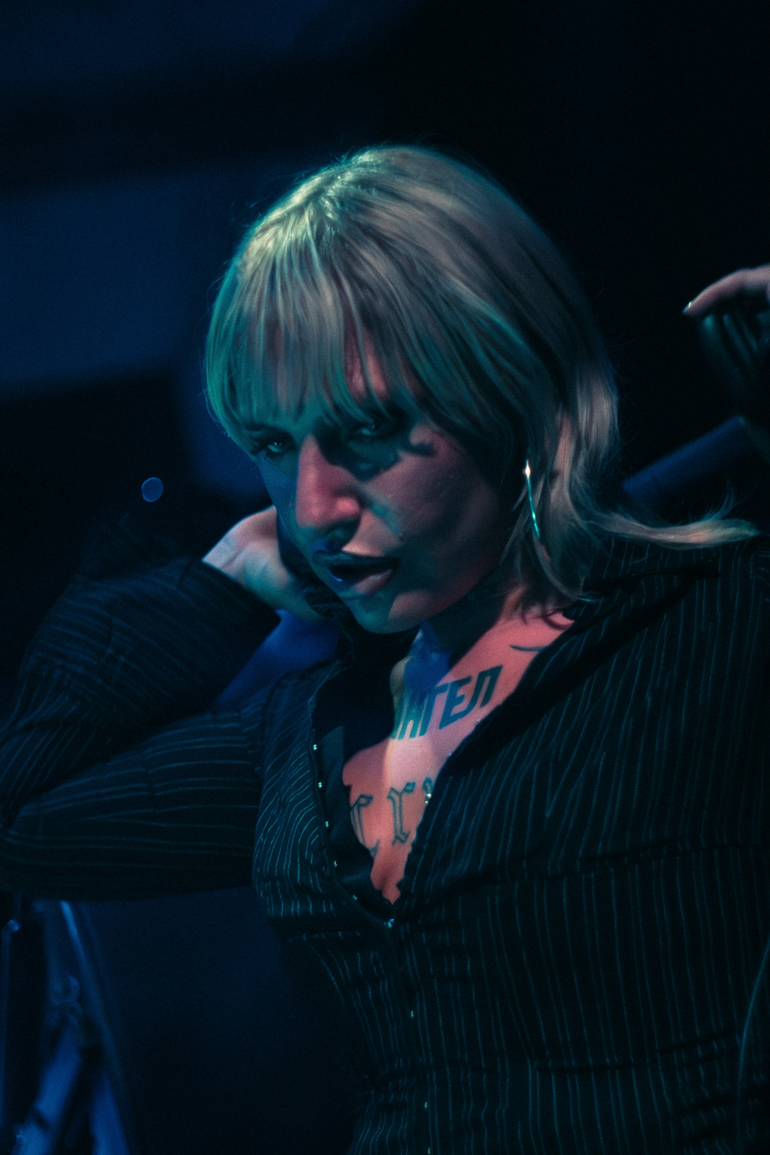 Blue-lit Gaze: Intimate Portrait Under Stage Lighting