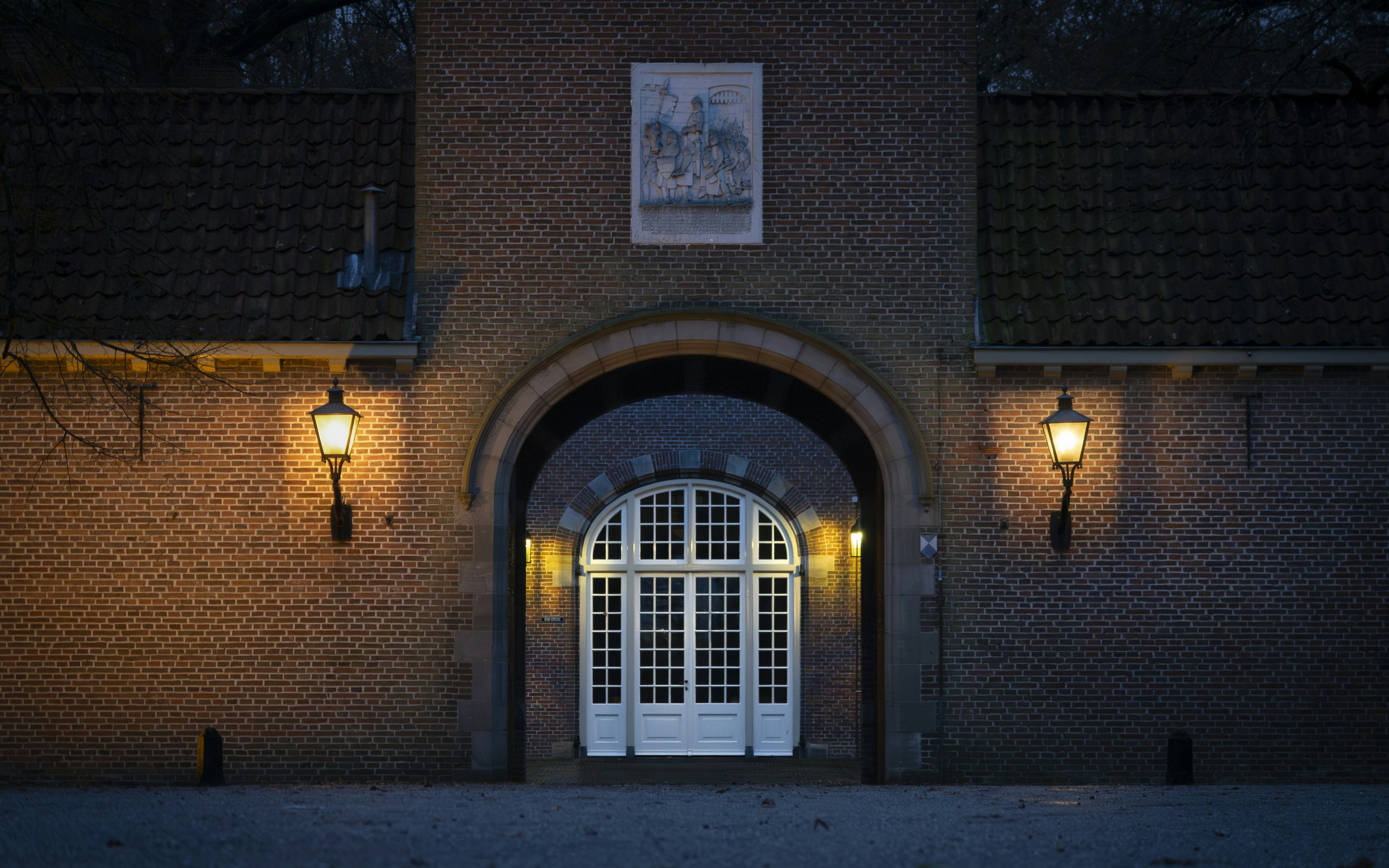 Lit Archway at Dusk: A Quiet Brick Entrance Framed by Warm Lanterns