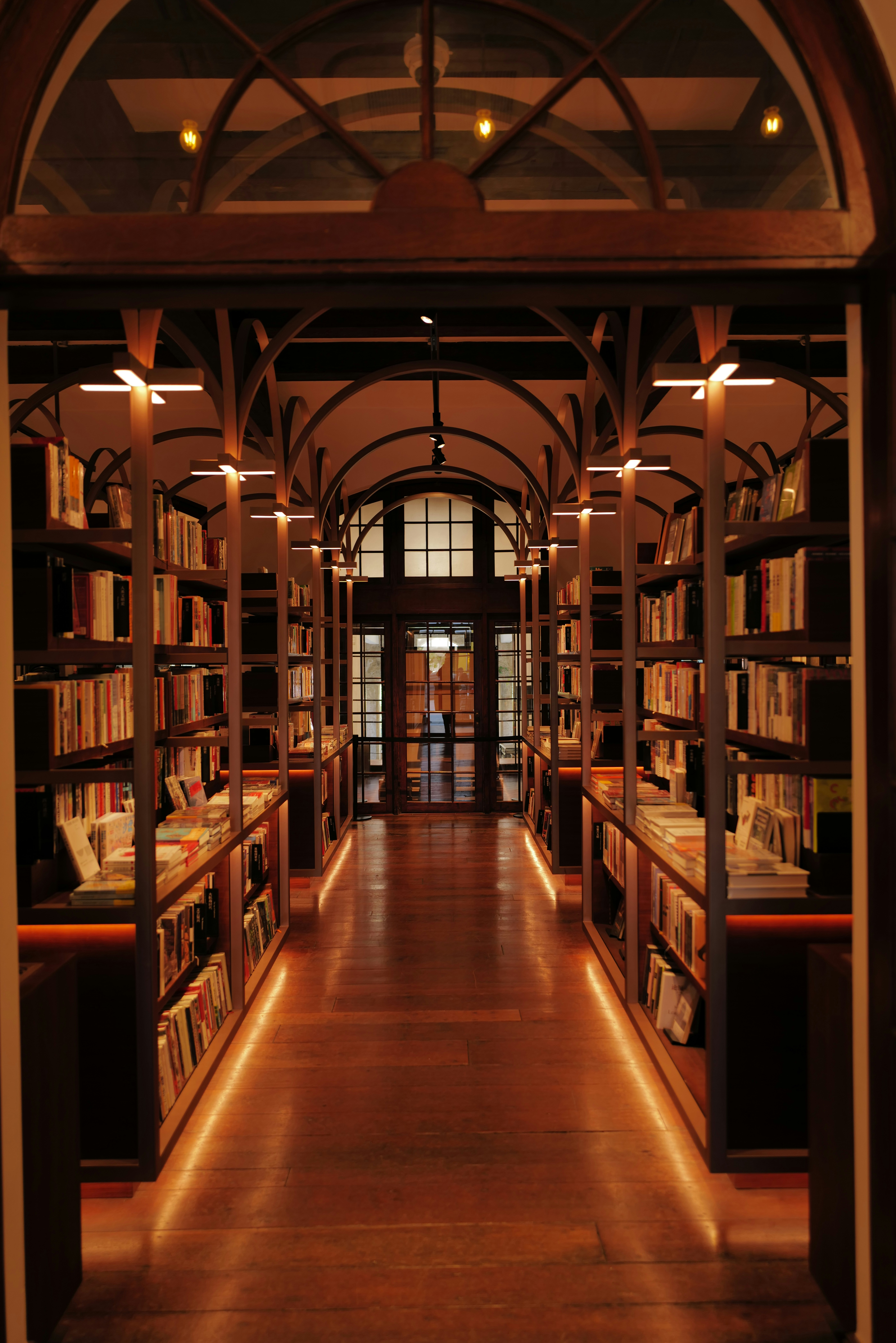 Symmetrical Library Aisle: Lantern-lit Path to the Glass Door