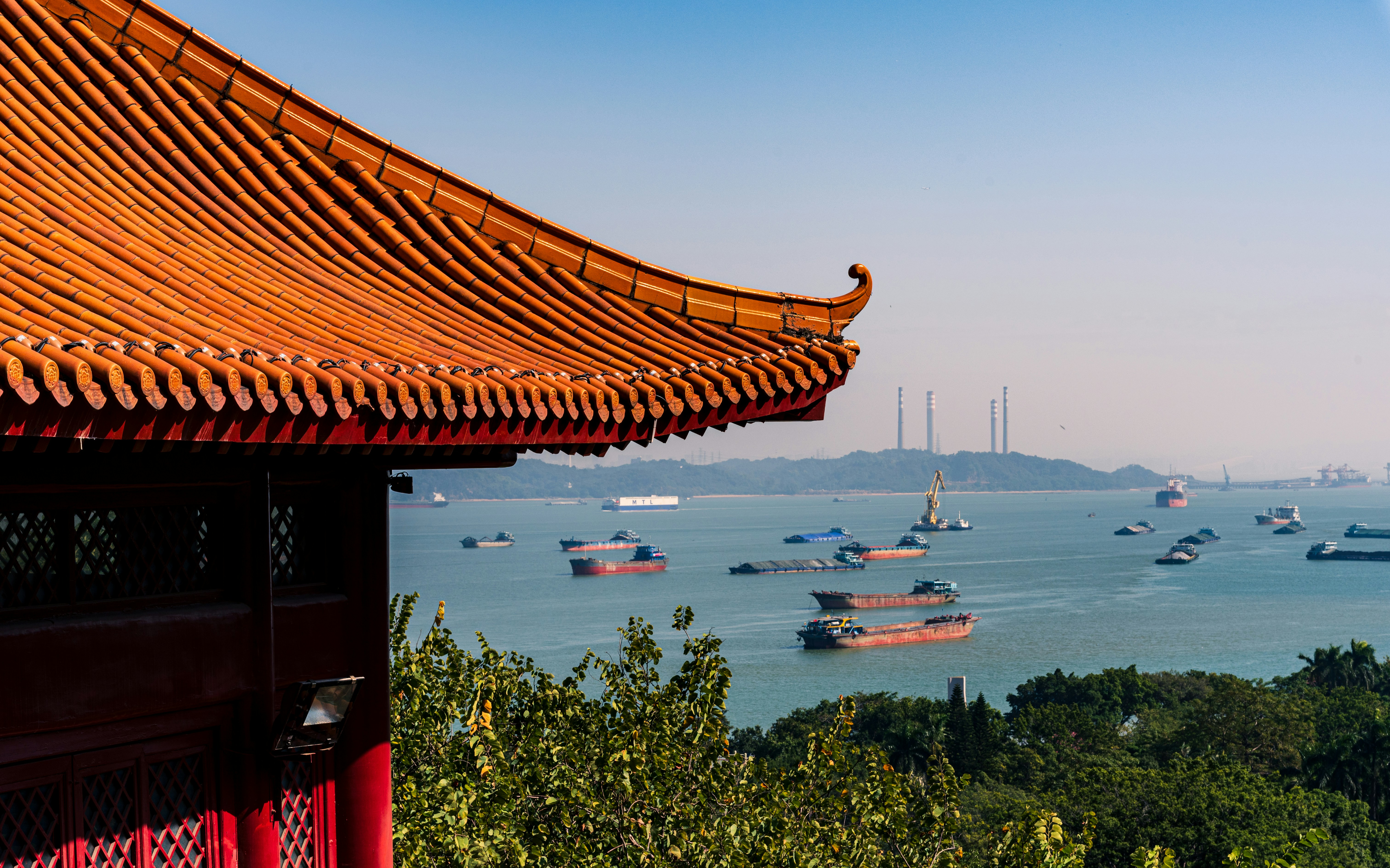 Overhang of a Red-Tiled Roof Overlooking a Serene Harbor