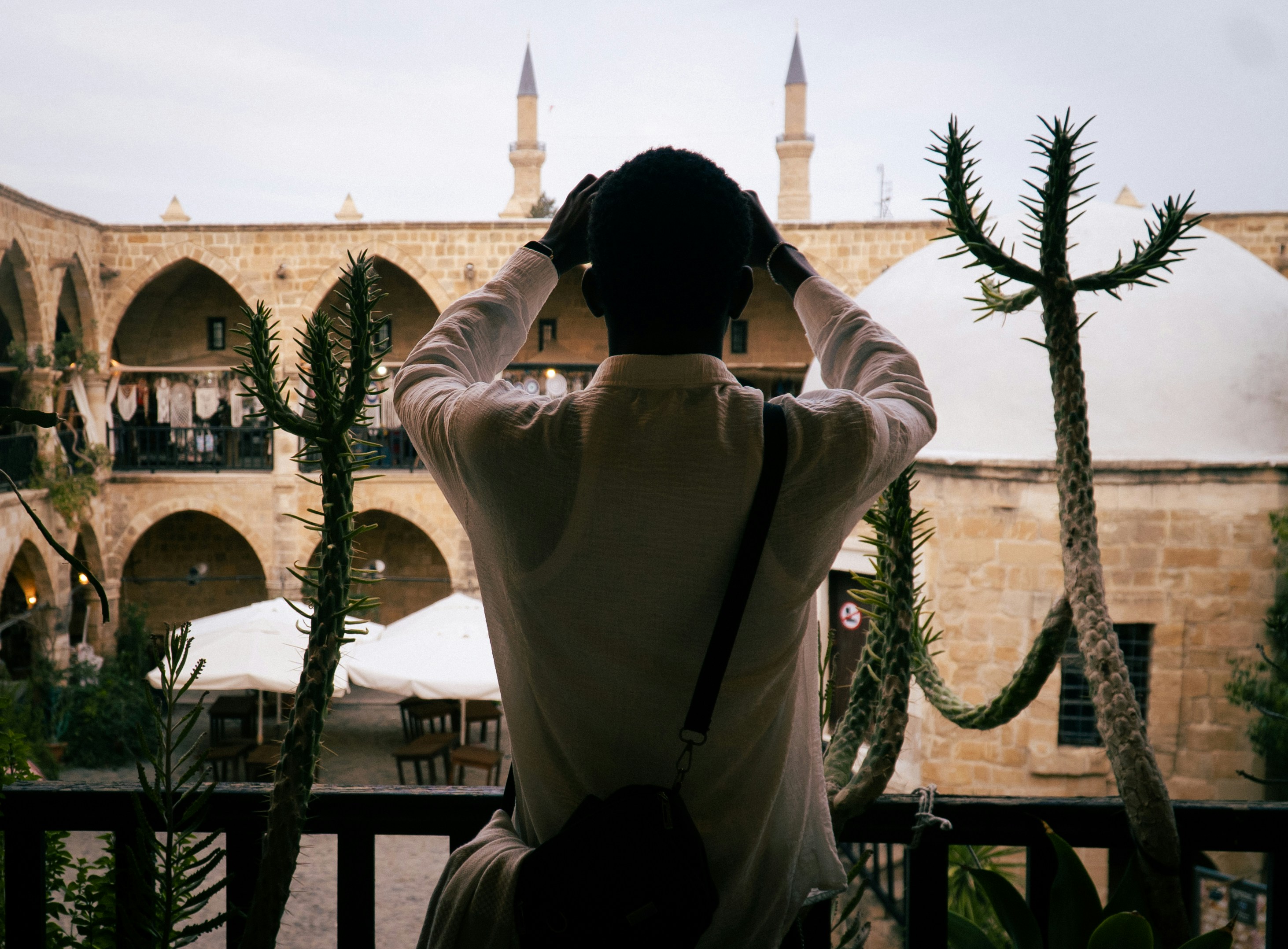 Traveler with Camera Surrounded by Cactus and Historic Courtyard