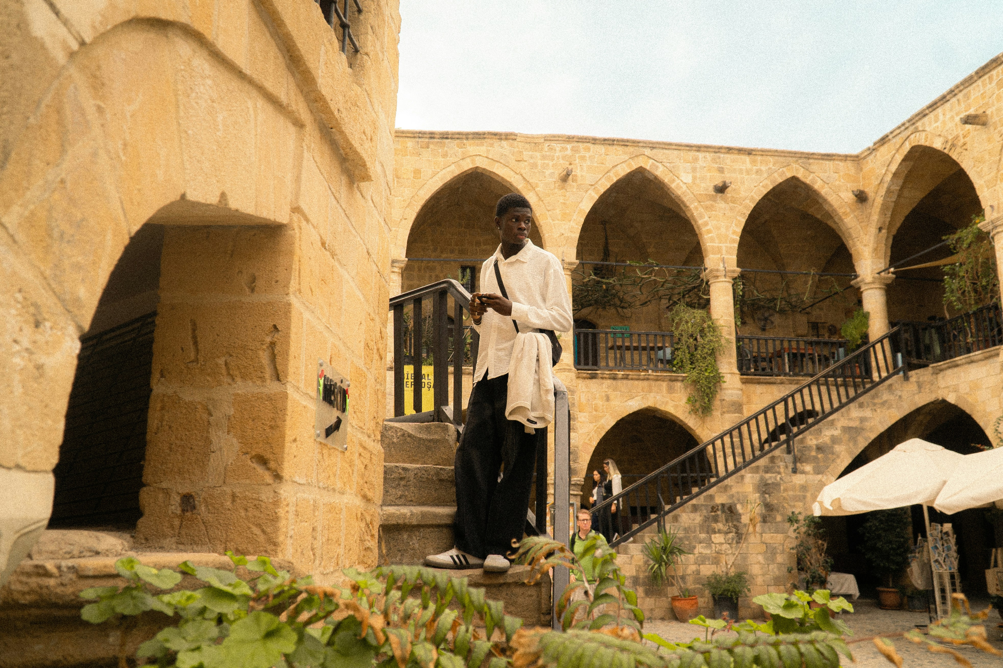 Chiaroscuro in the Courtyard: A Figure Among Aged Arches