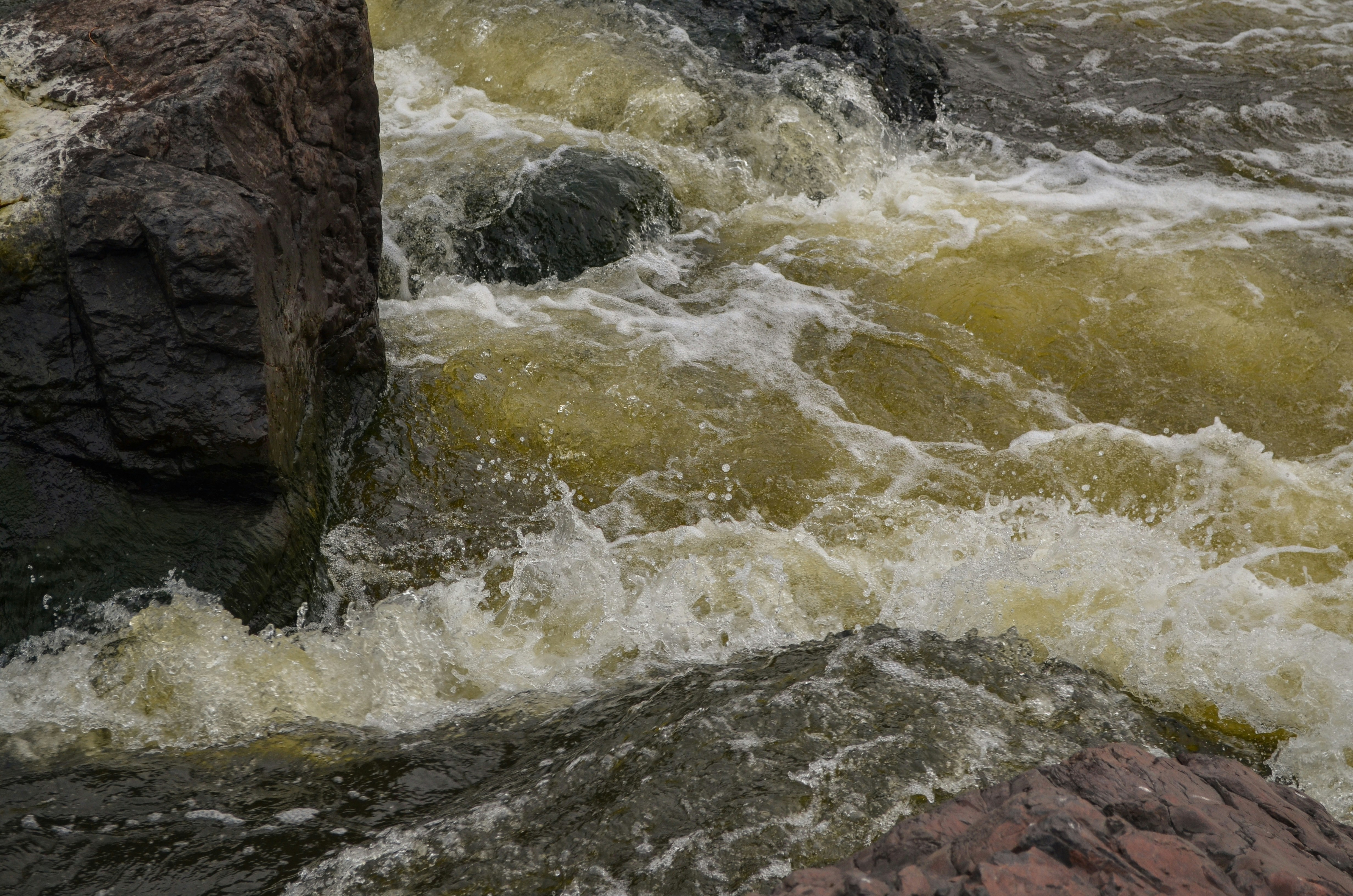 Rough Waters Crest Over Rounded River Rocks