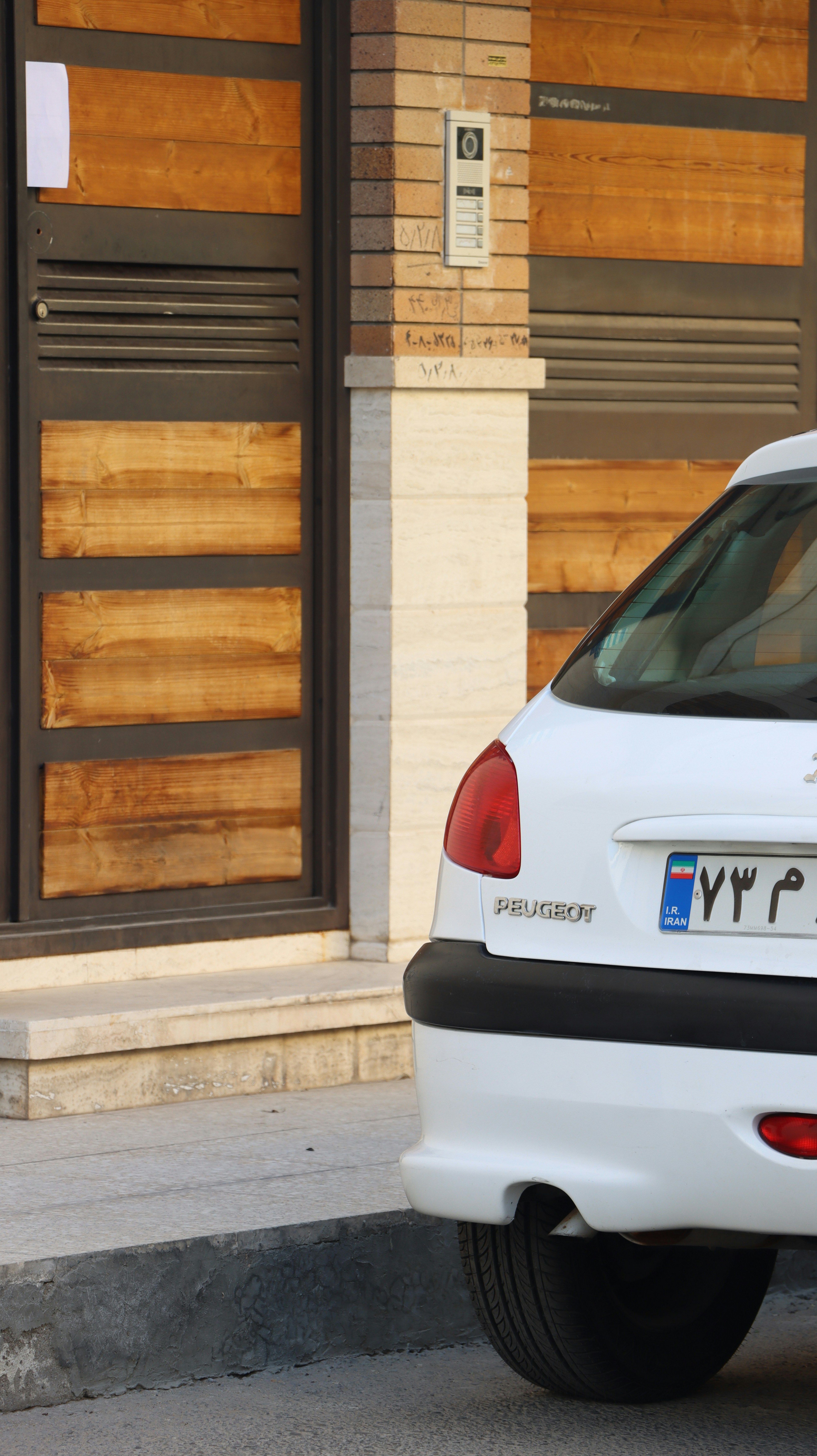 White Peugeot Stopped at a Stone-Faced Entrance