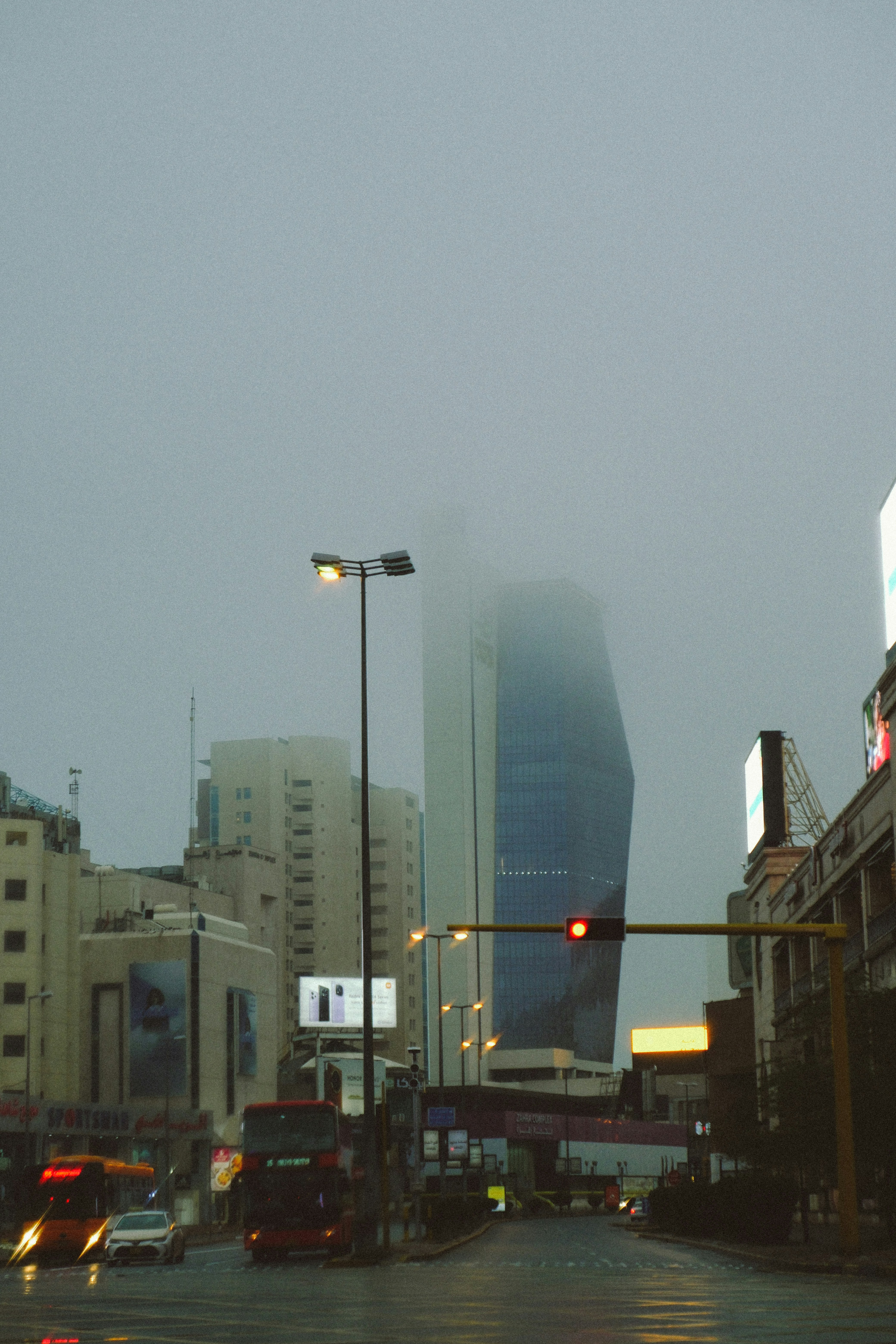 Rainy city avenue toward a glass-skyscraper pierce
