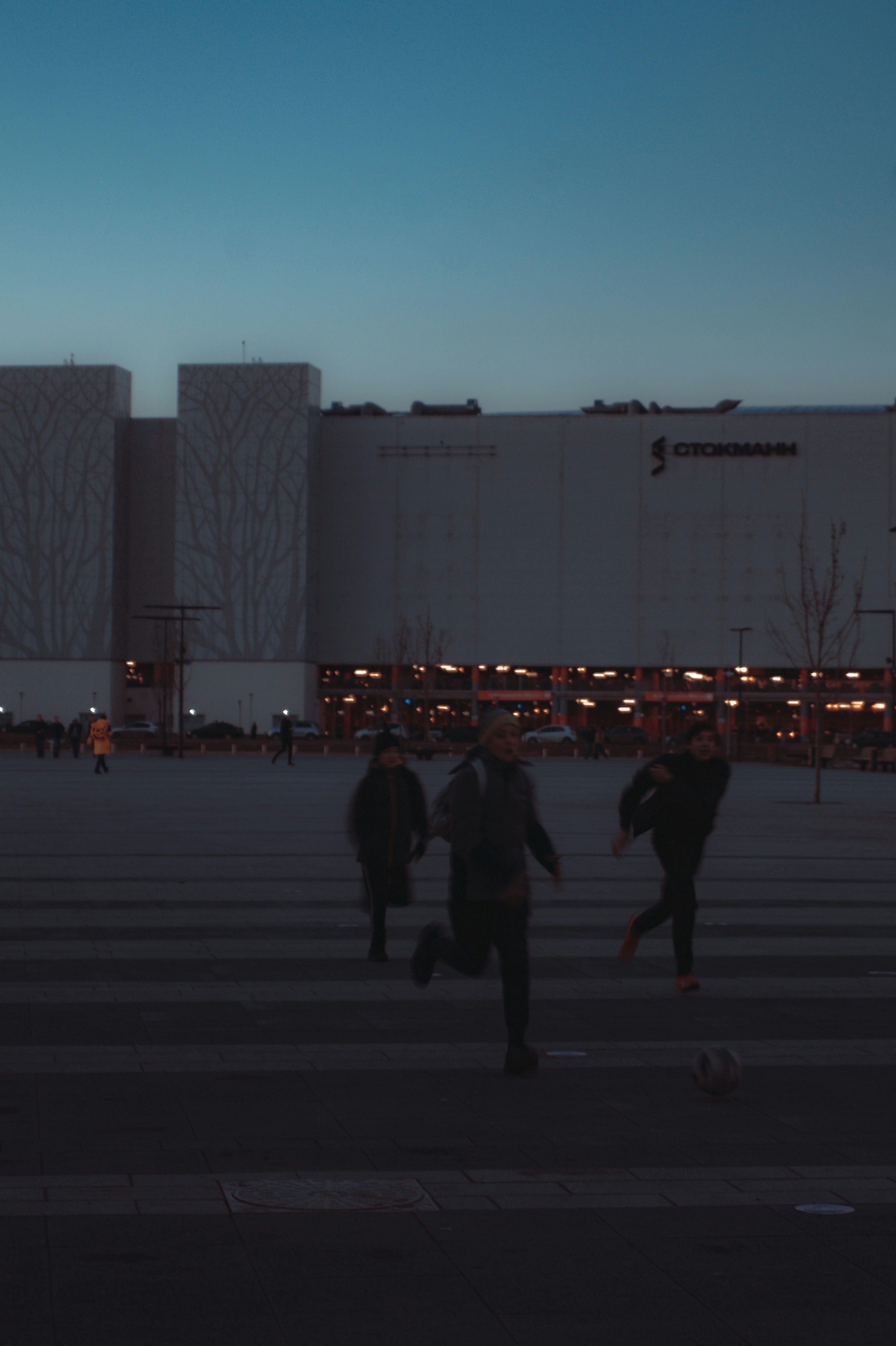 Evening Run Across a Quiet Plaza in Front of a Modern Complex