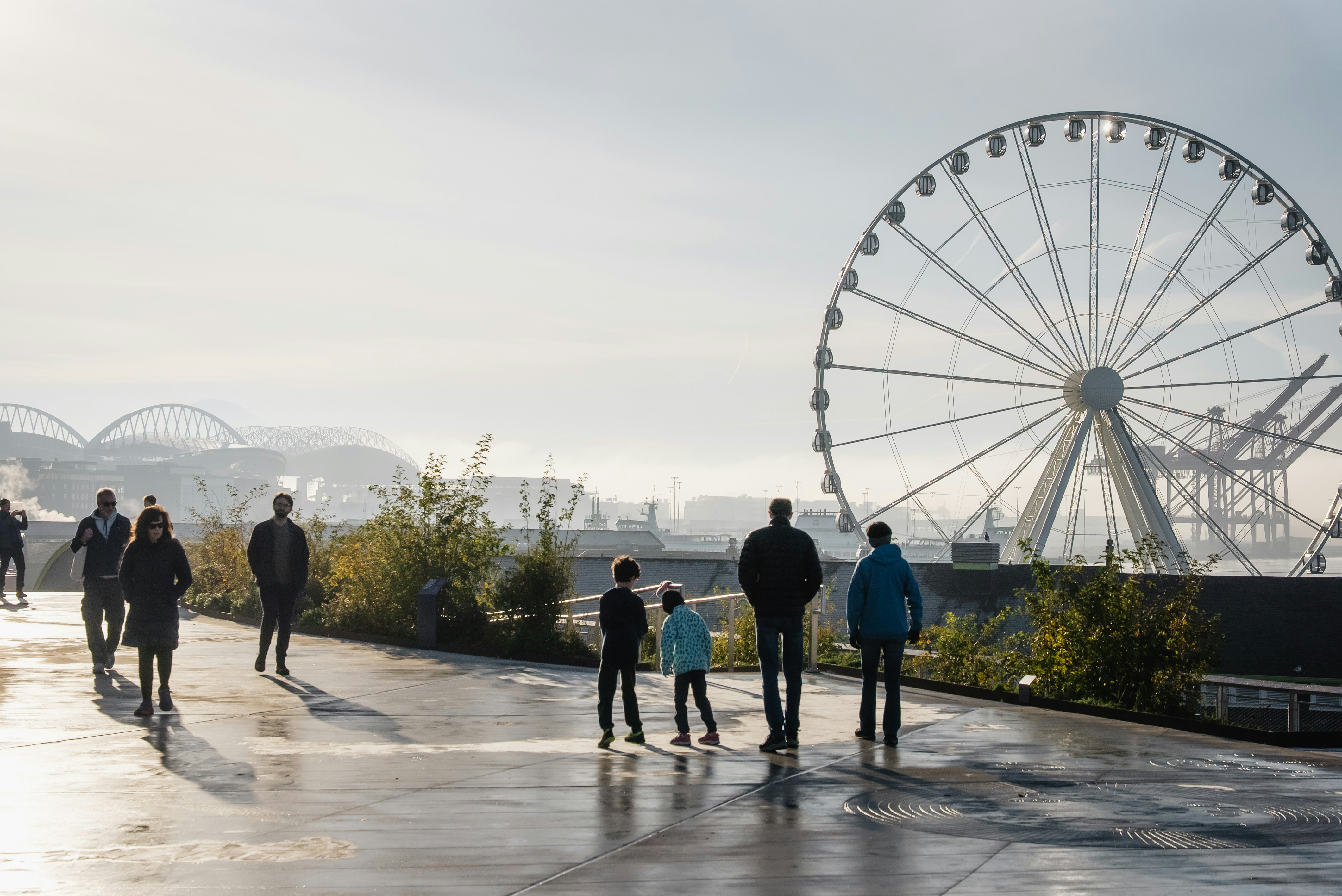 Riverside Promenade: Families and a Giant Wheel at Dusk