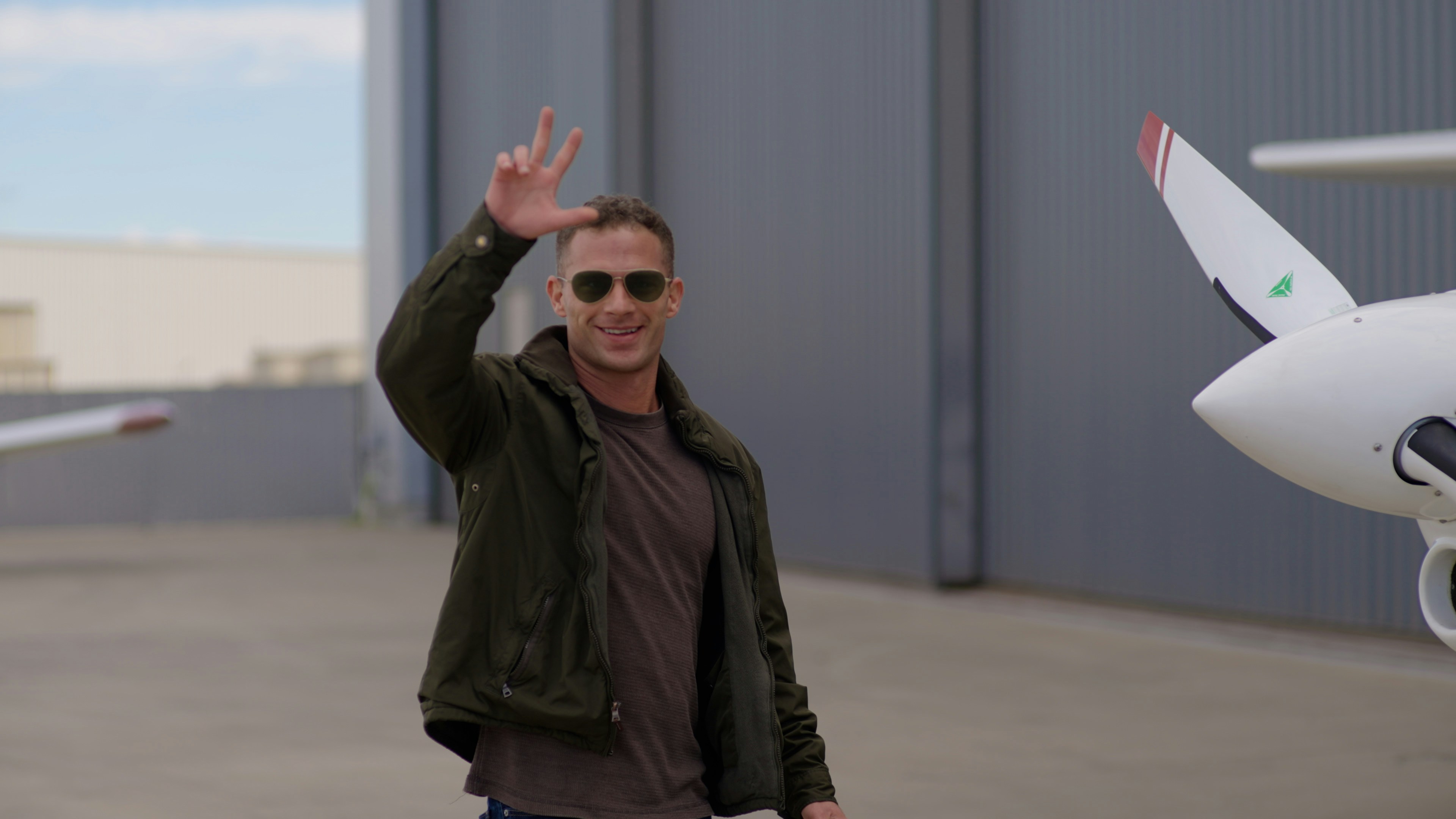 Man waving hello near airplanes at hangar. photo – Free Travel Image on ...