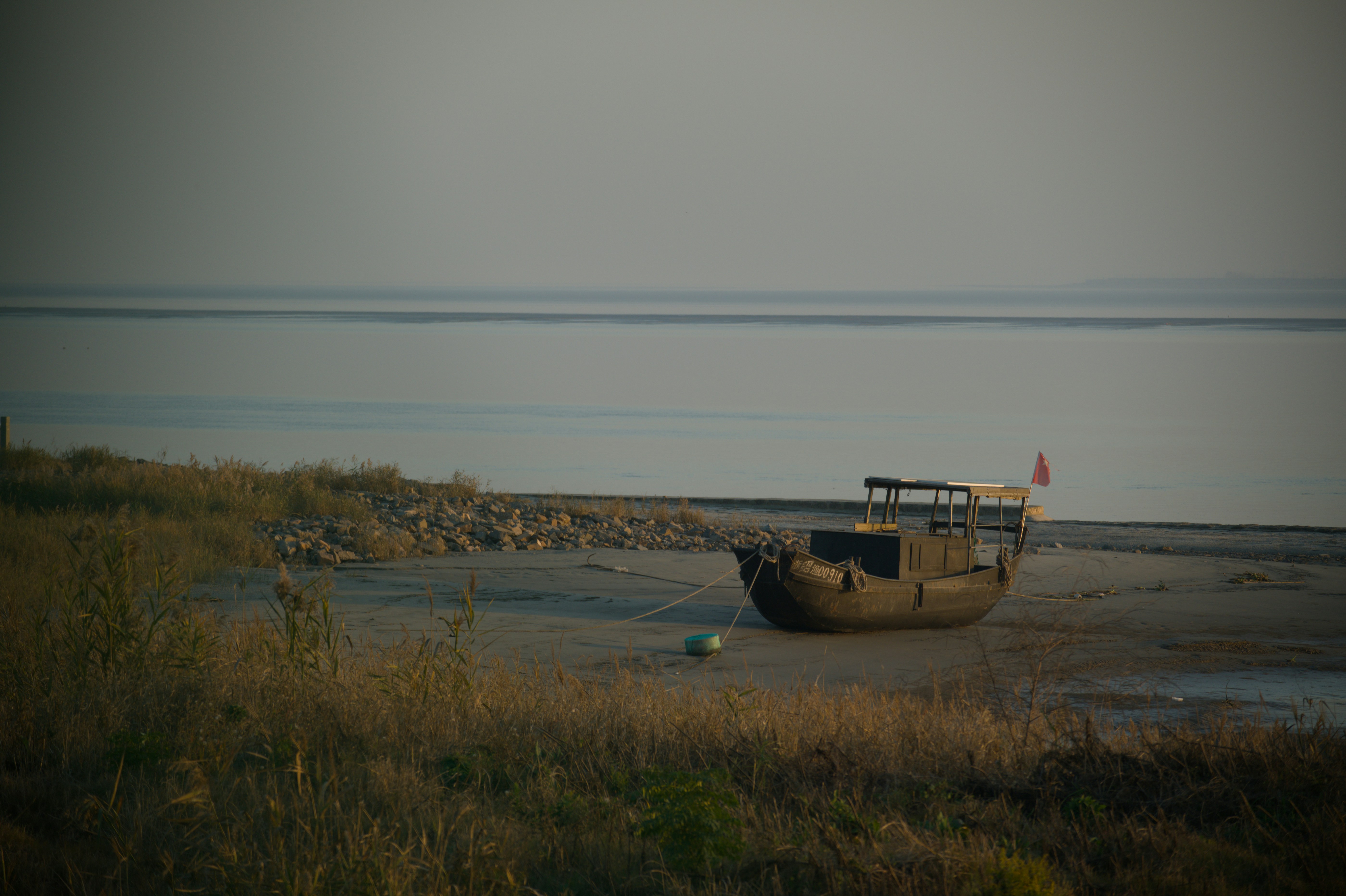 Silent Shoreline Docked Vessel Amid Quiet Dusk