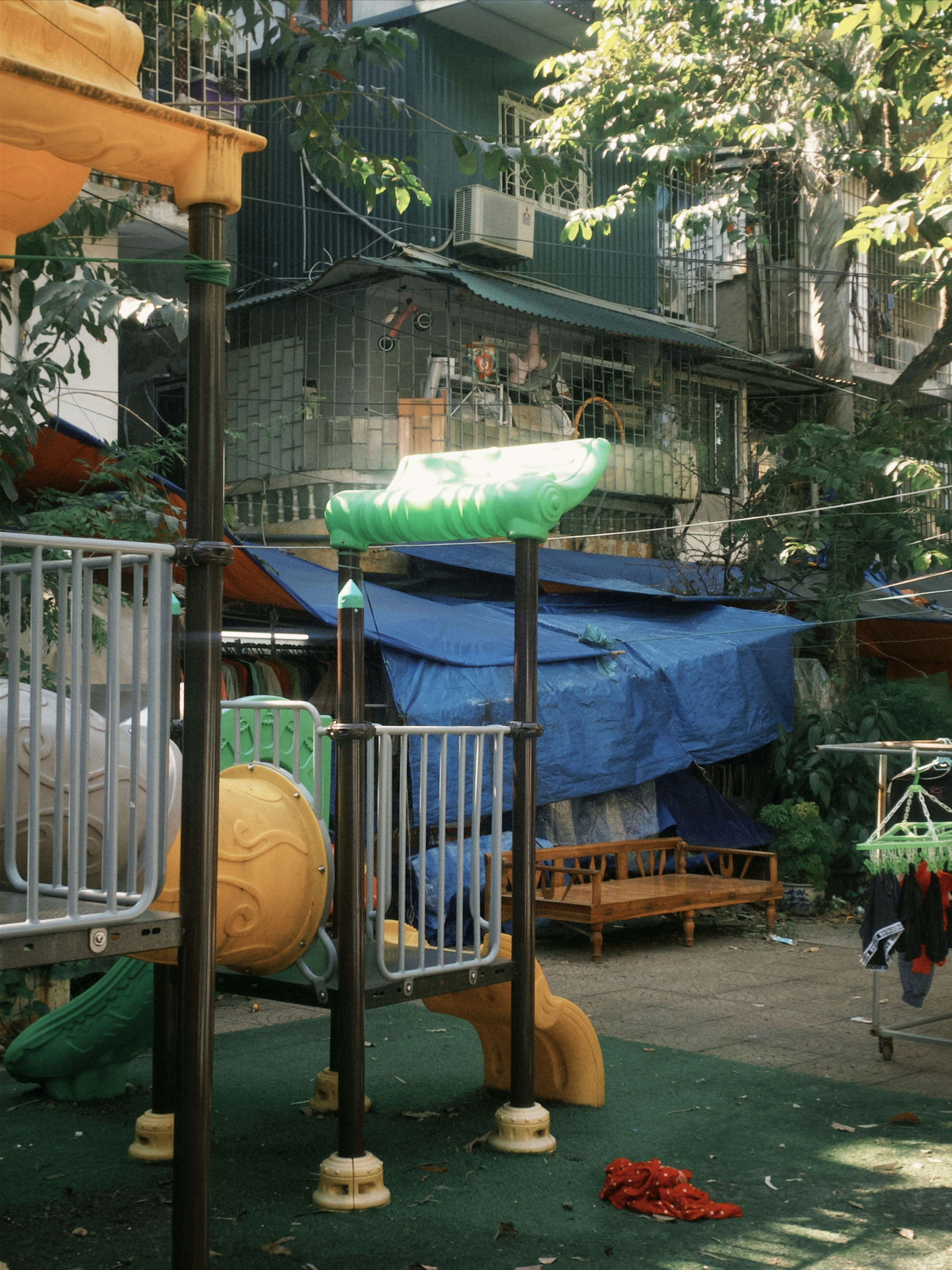 Green Slide Canopy Over a Weathered Urban Playground