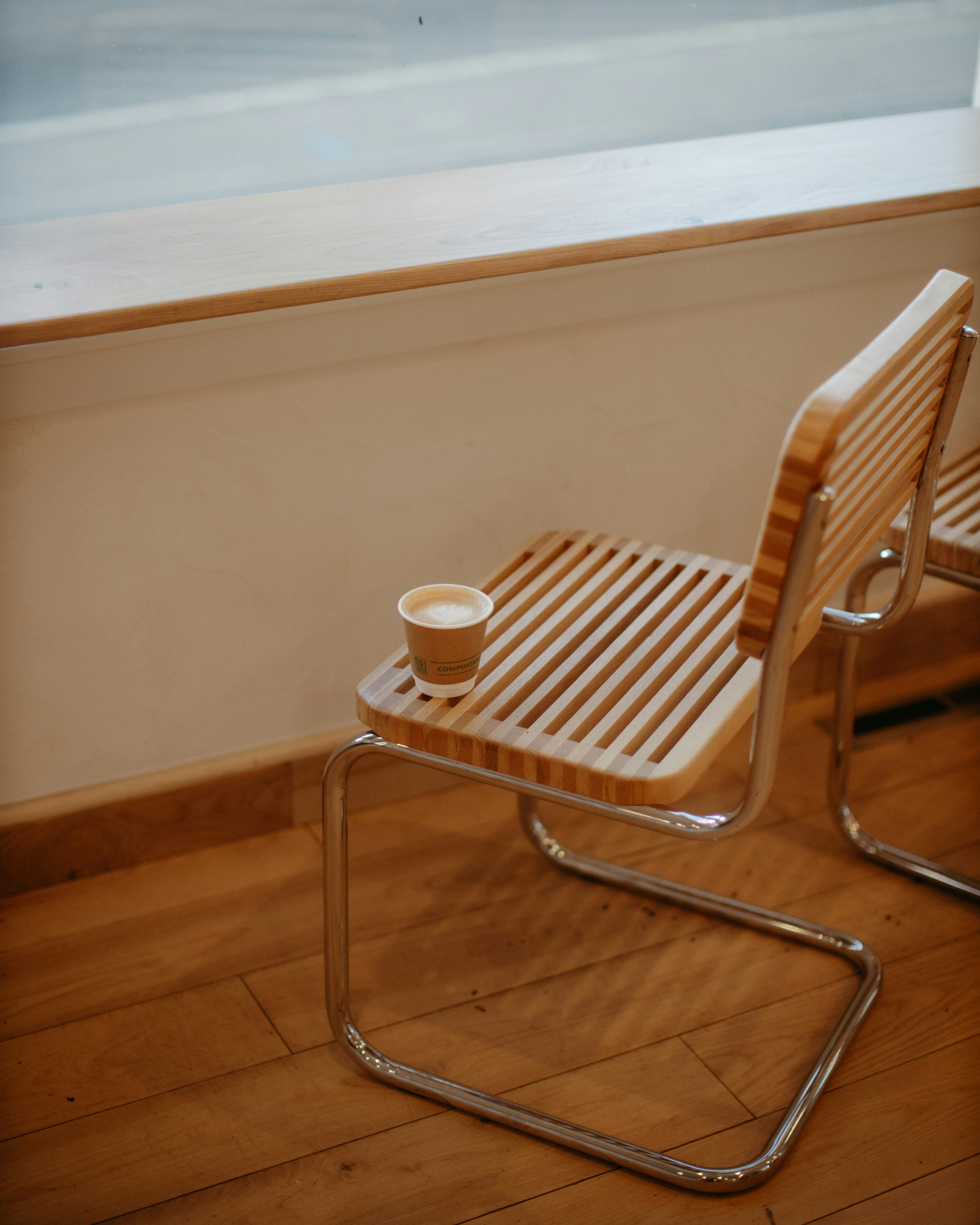 A coffee cup sits on a modern wooden chair. photo – Free Interior ...