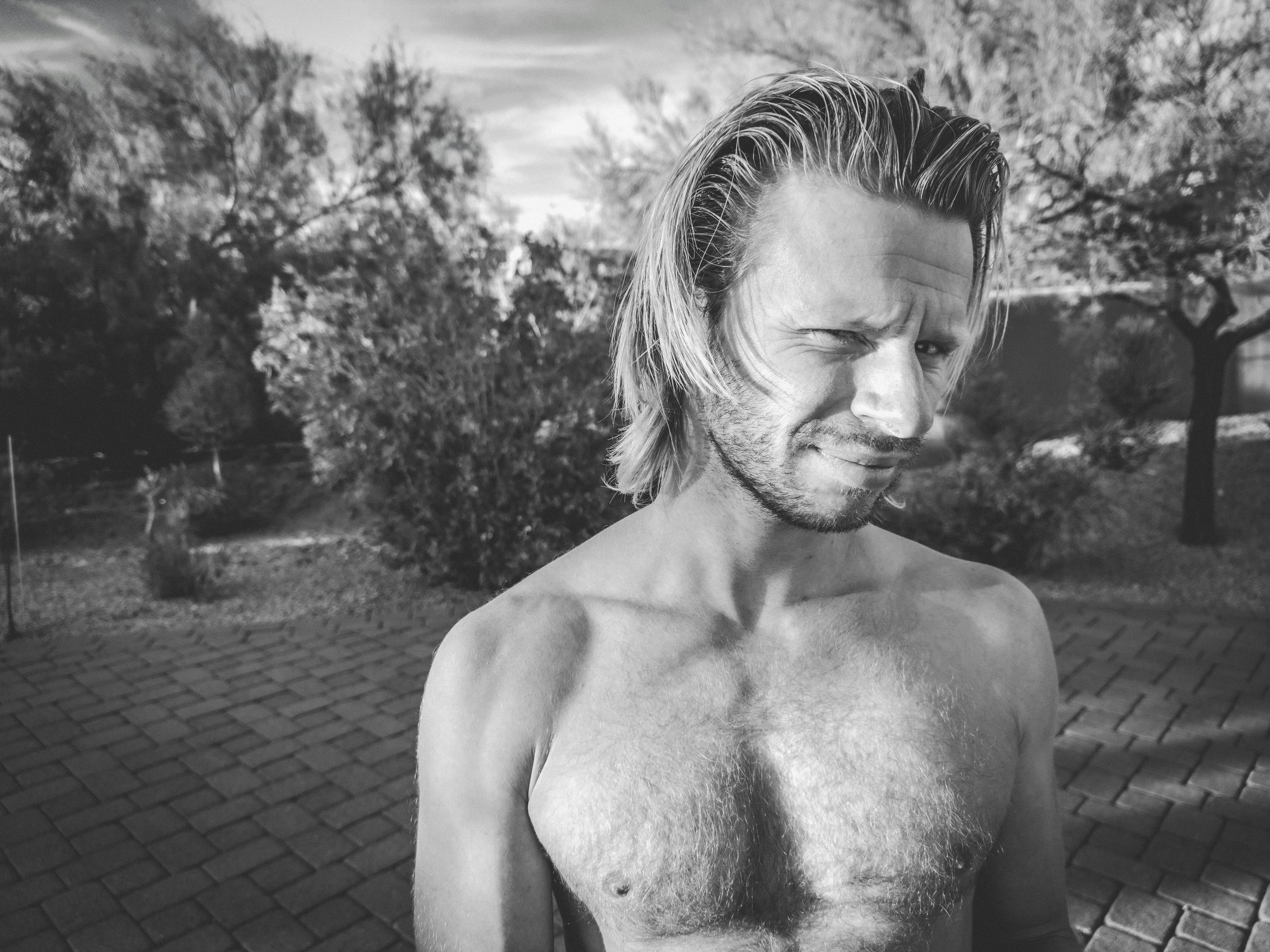 Sunlit Contemplation: A Shirtless Portrait in Quiet Park Light