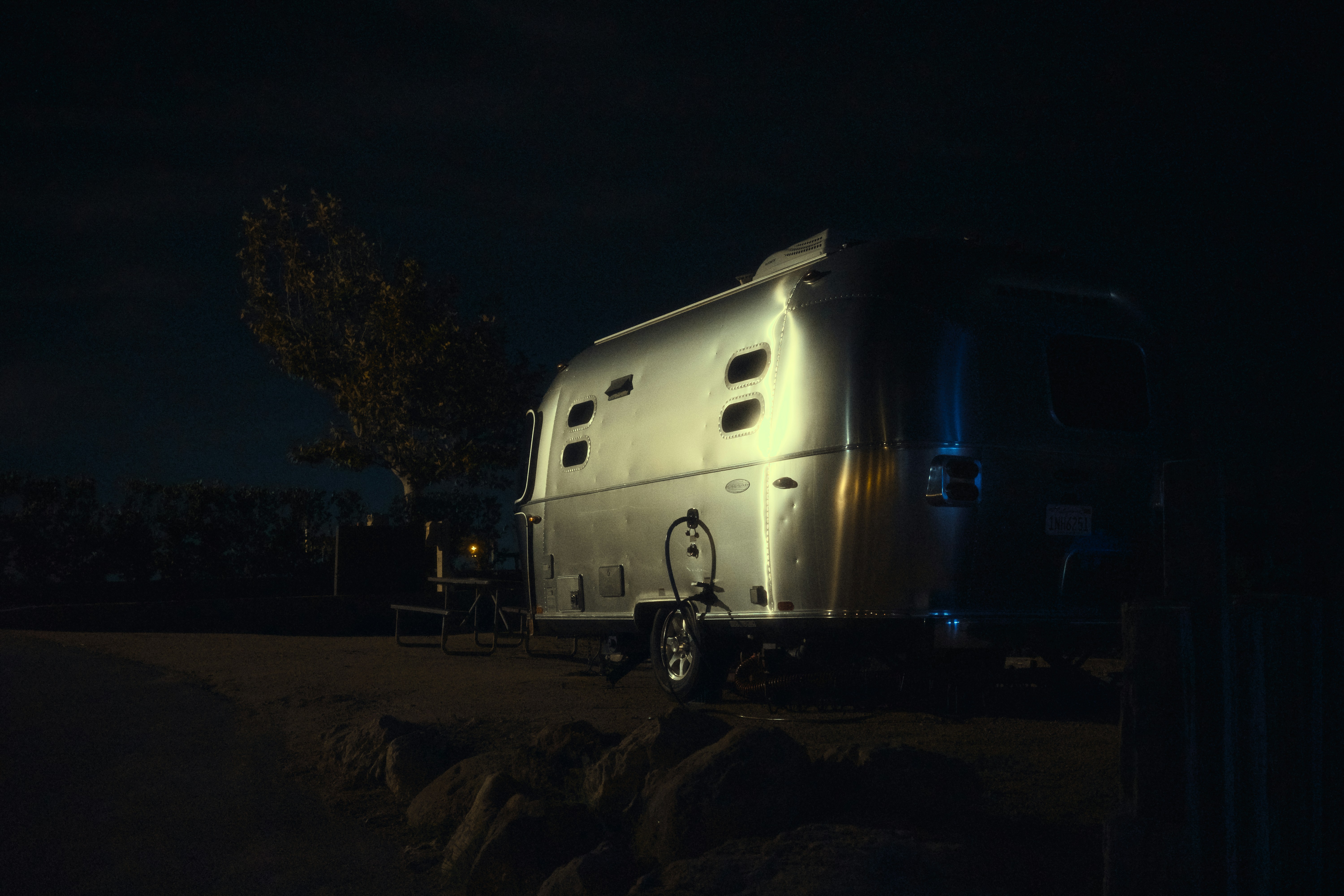 Night at the Aluminum Caravan: Subtle Glow on a Quiet Campsite
