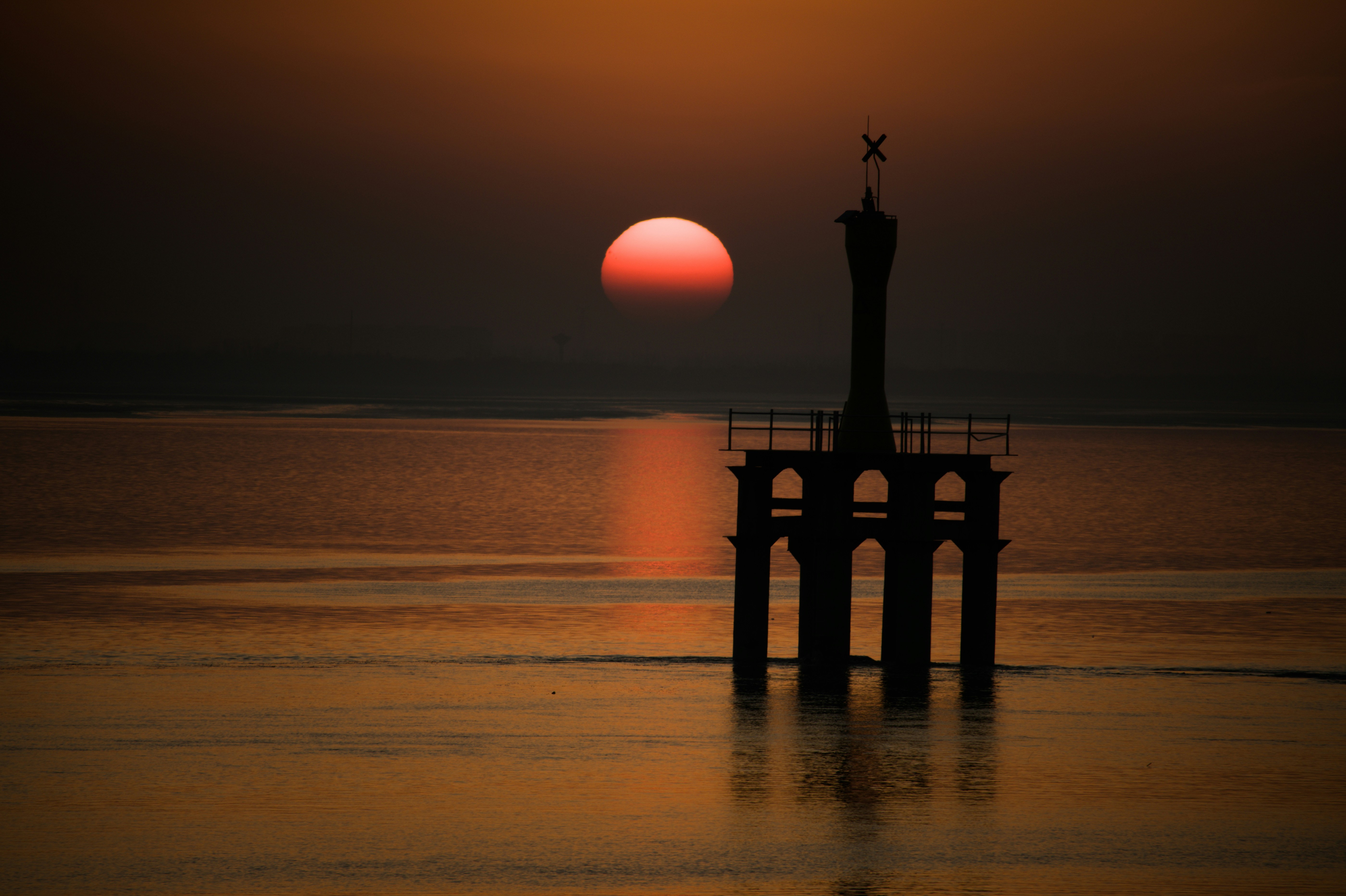 Silhouette at Dusk: Sun, Pier, and a Quiet Horizon