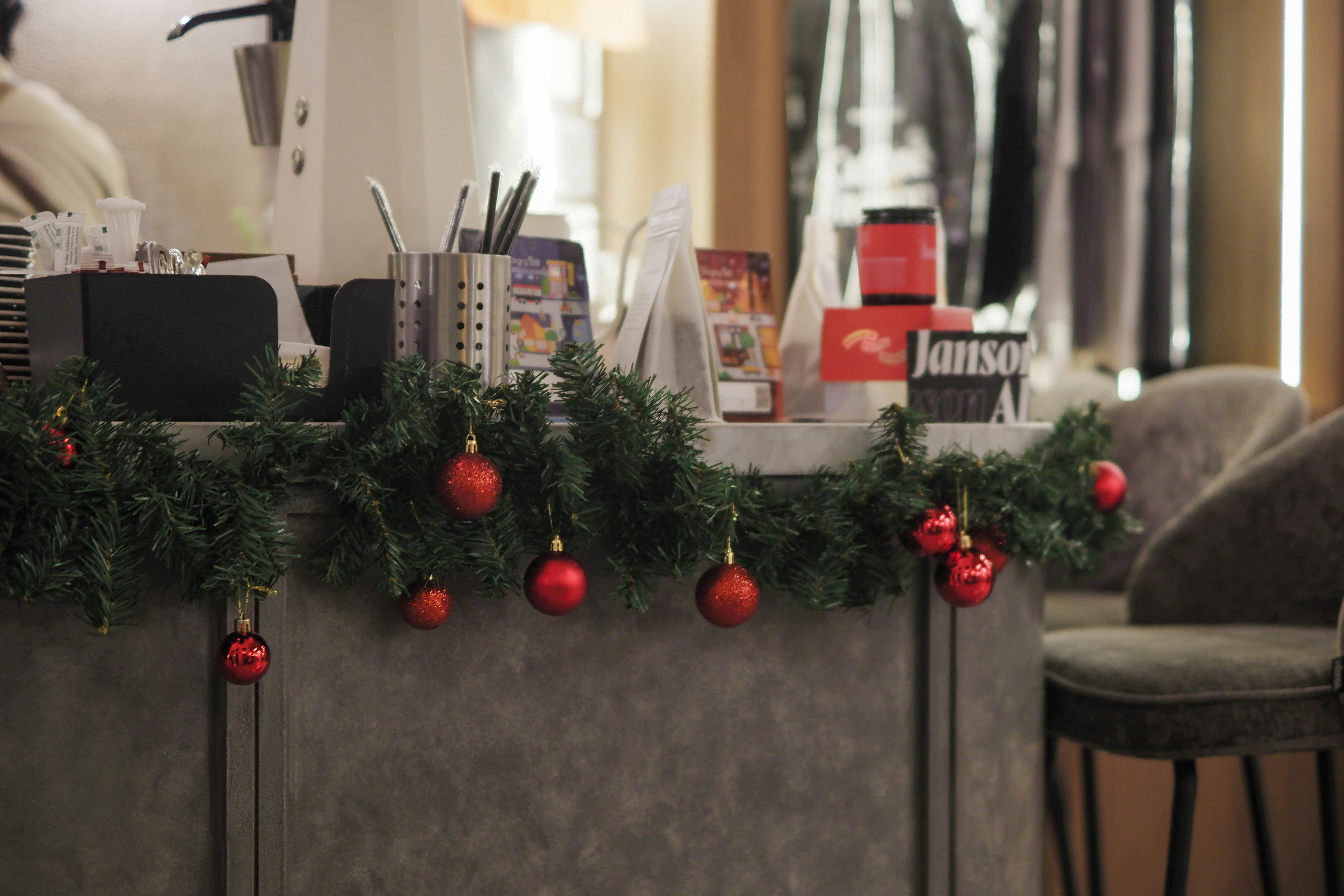 Festive Front Counter: Greenery and Red Ornaments Framing a Cozy Café Scene