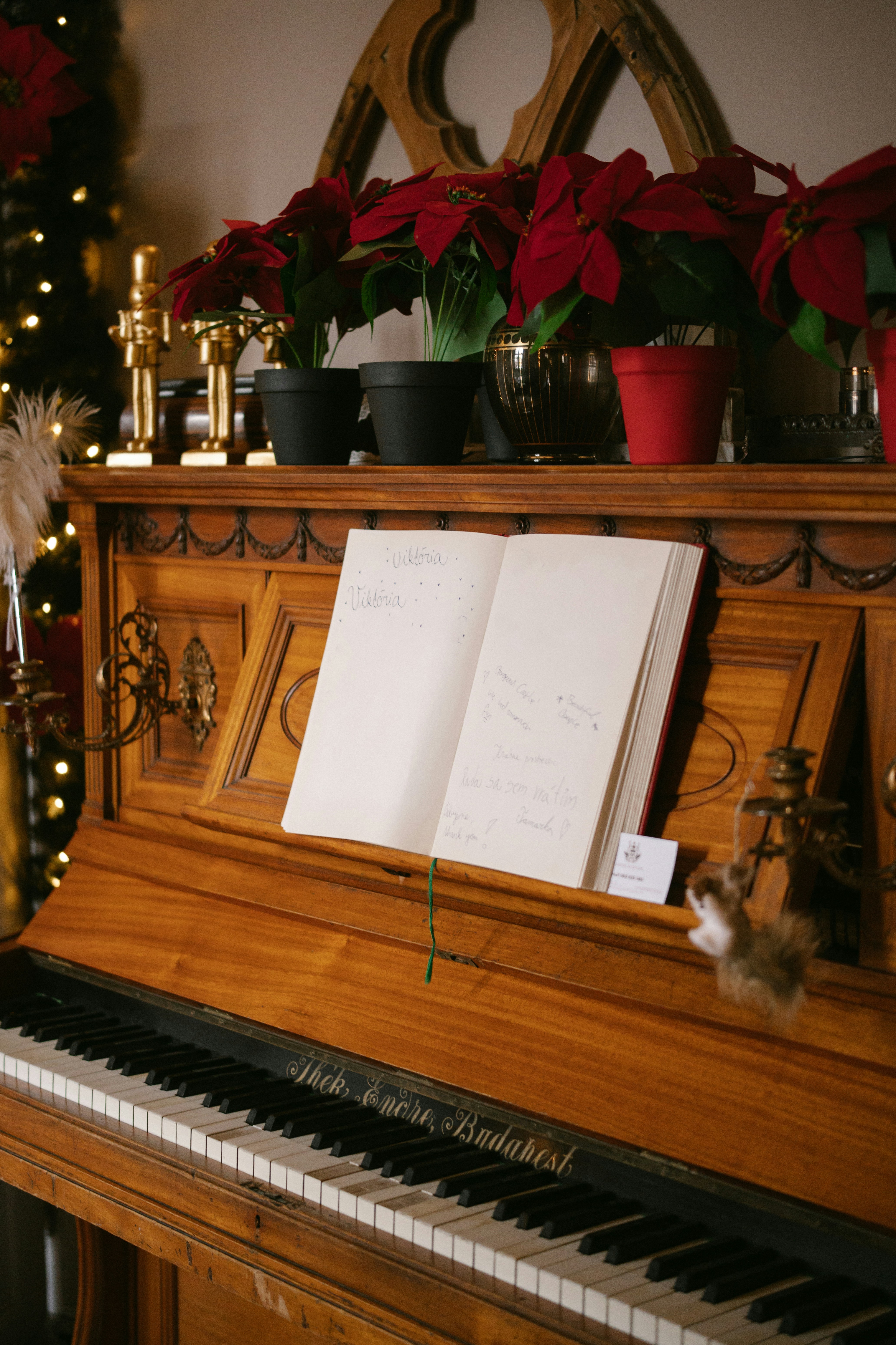 Open book on a wooden piano with poinsettias.