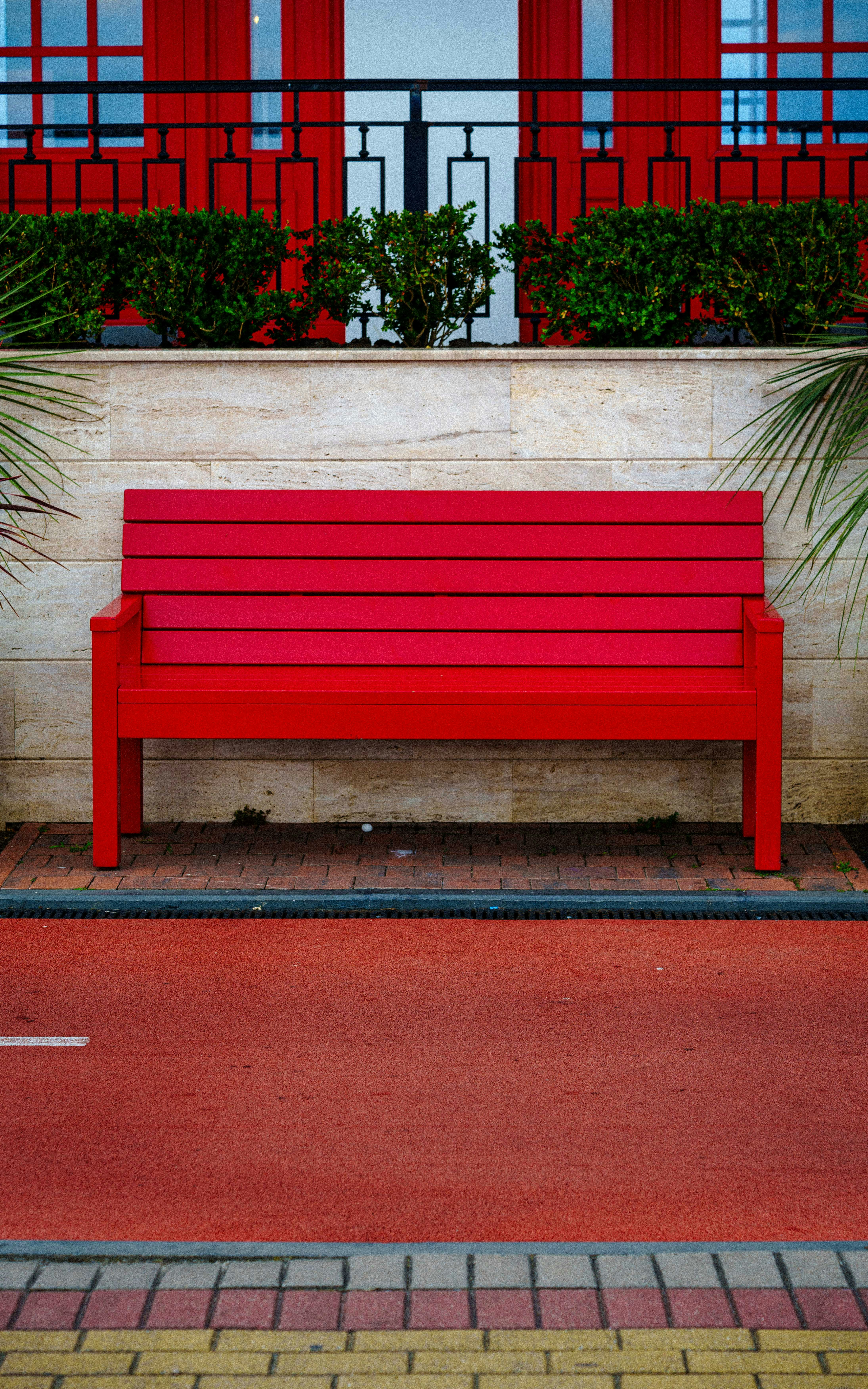 Red Bench, Quiet Courtyard: A Bold Splash of Color