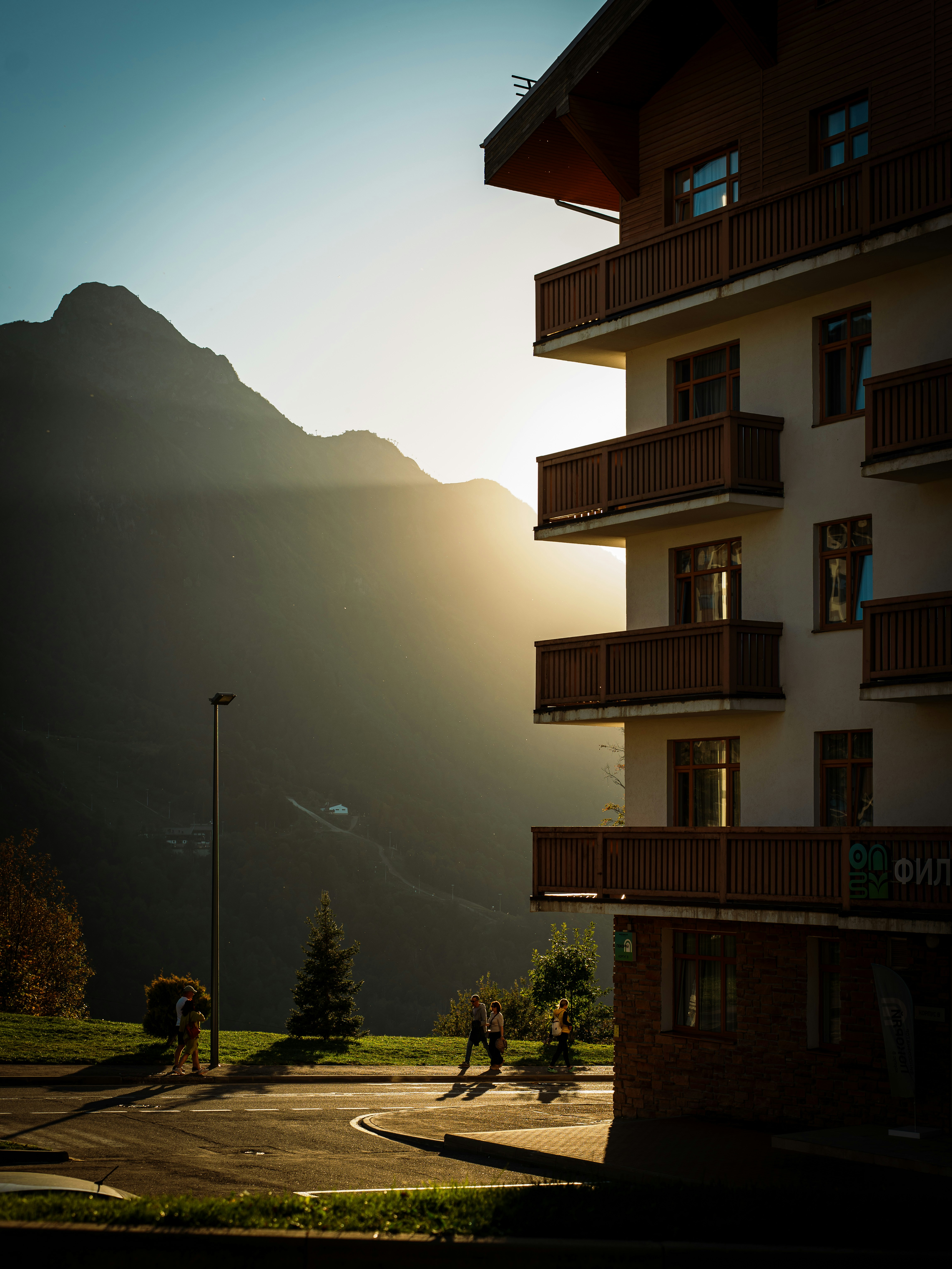 Sunlit Balcony Facade with Mountain Backdrop at Dusk