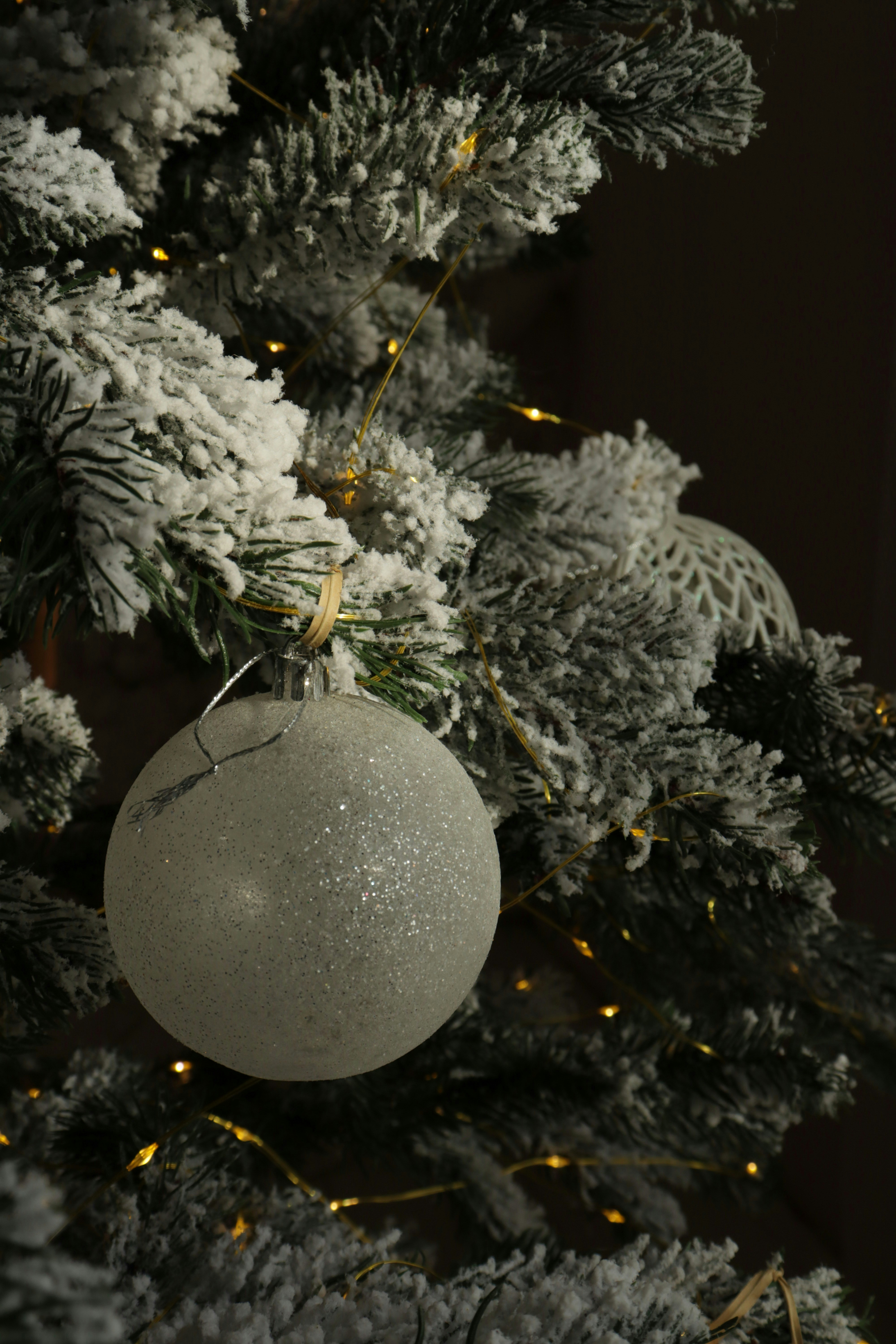 Snow-Kissed Ornament Under Warm Fairy Lights