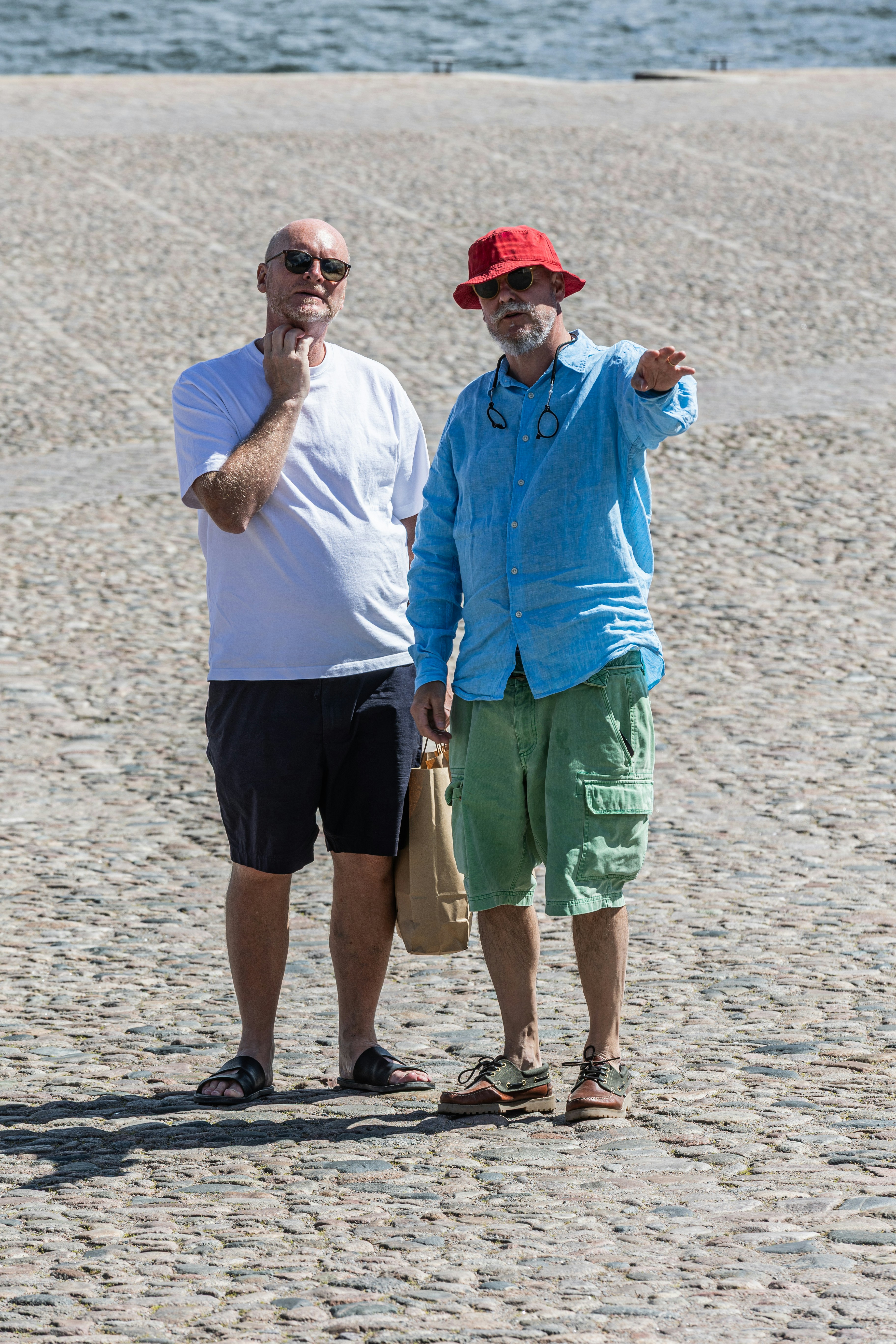Two middle aged men have stopped to discuss the meaning of a statue near the waterfront in Karlskrona.