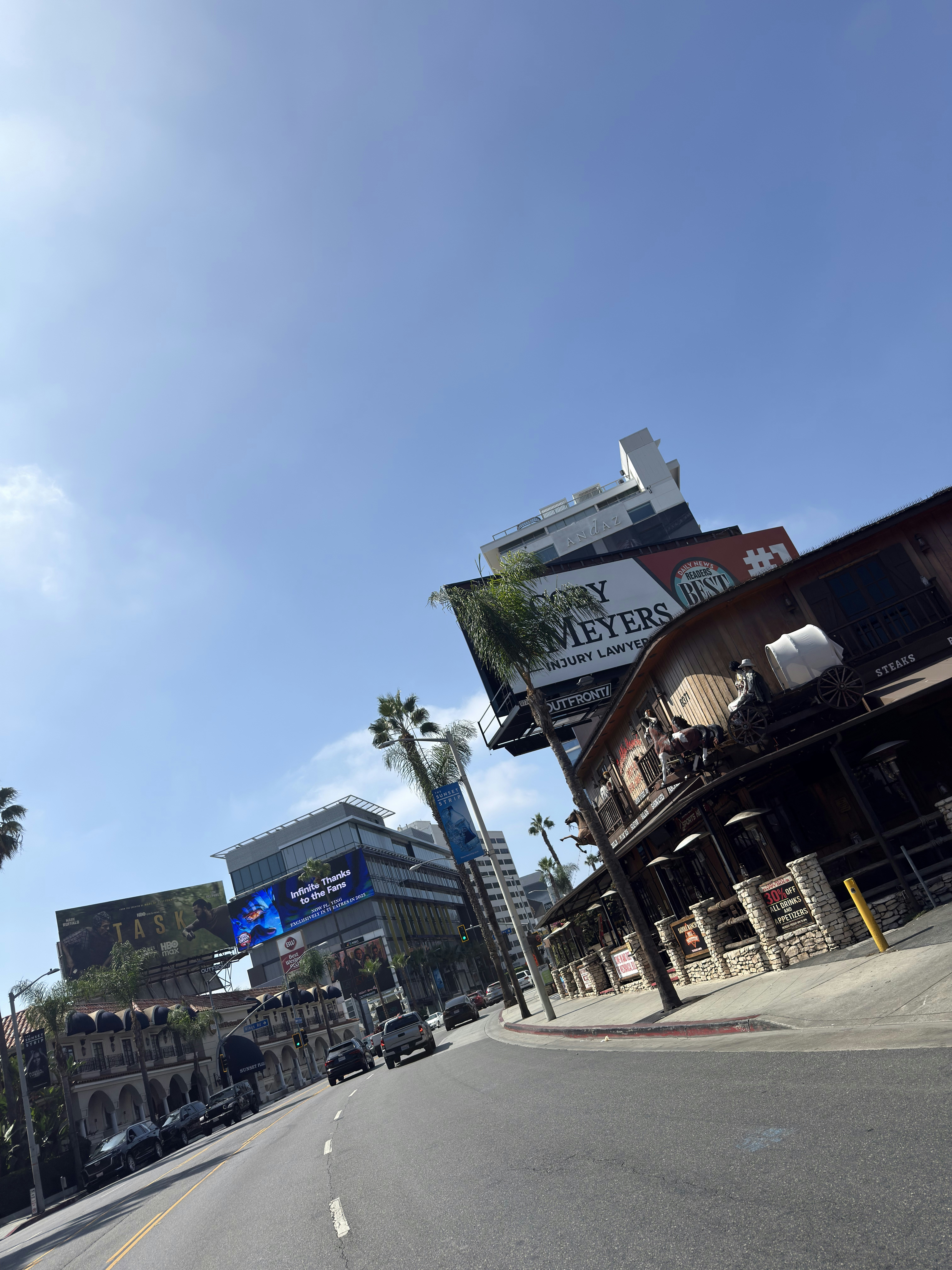 Urban Arc: A Sunlit Boulevard Framed by Signage and Facades