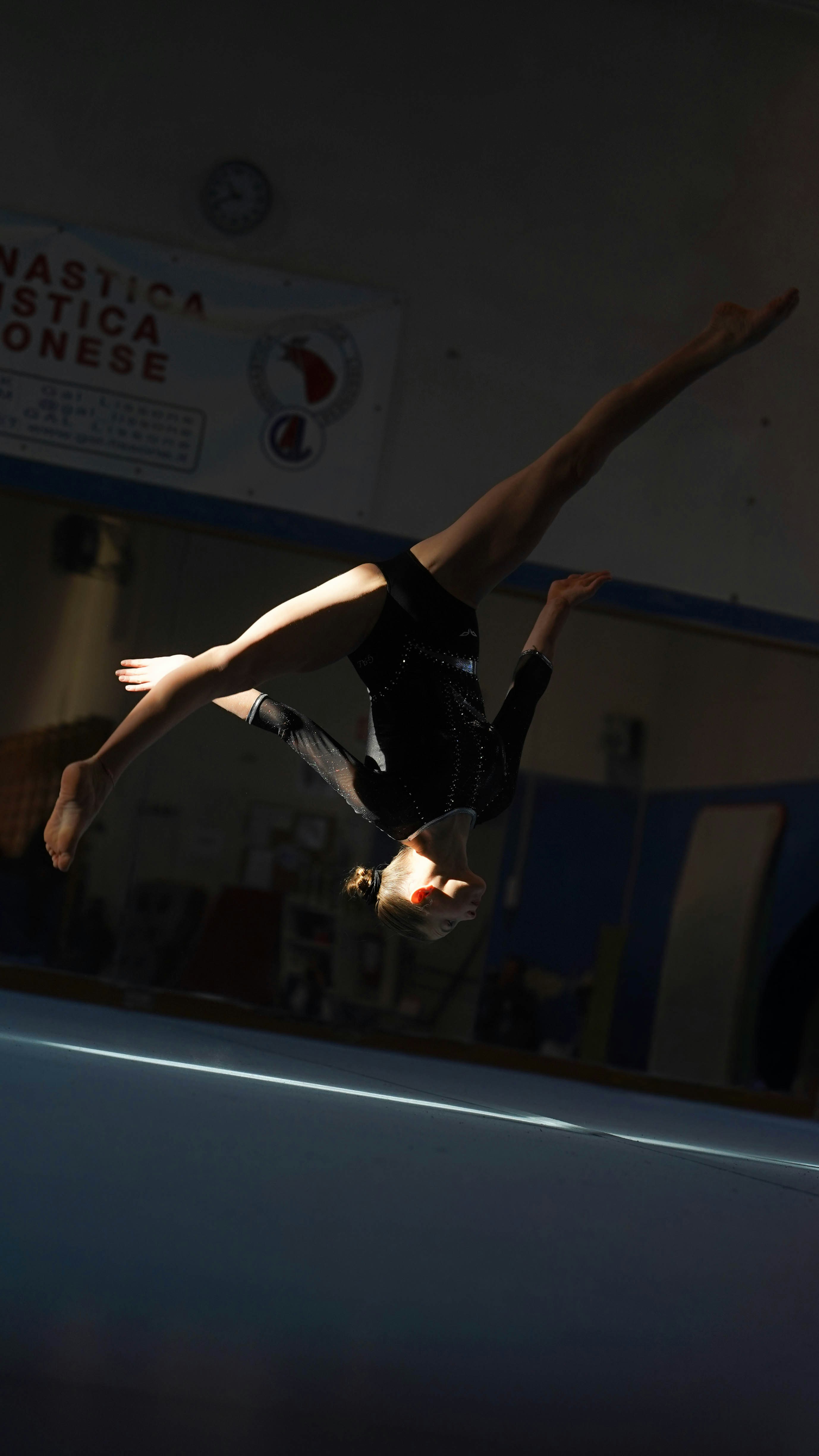 Midair Grace: A gymnast suspended in a dramatic inverted leap