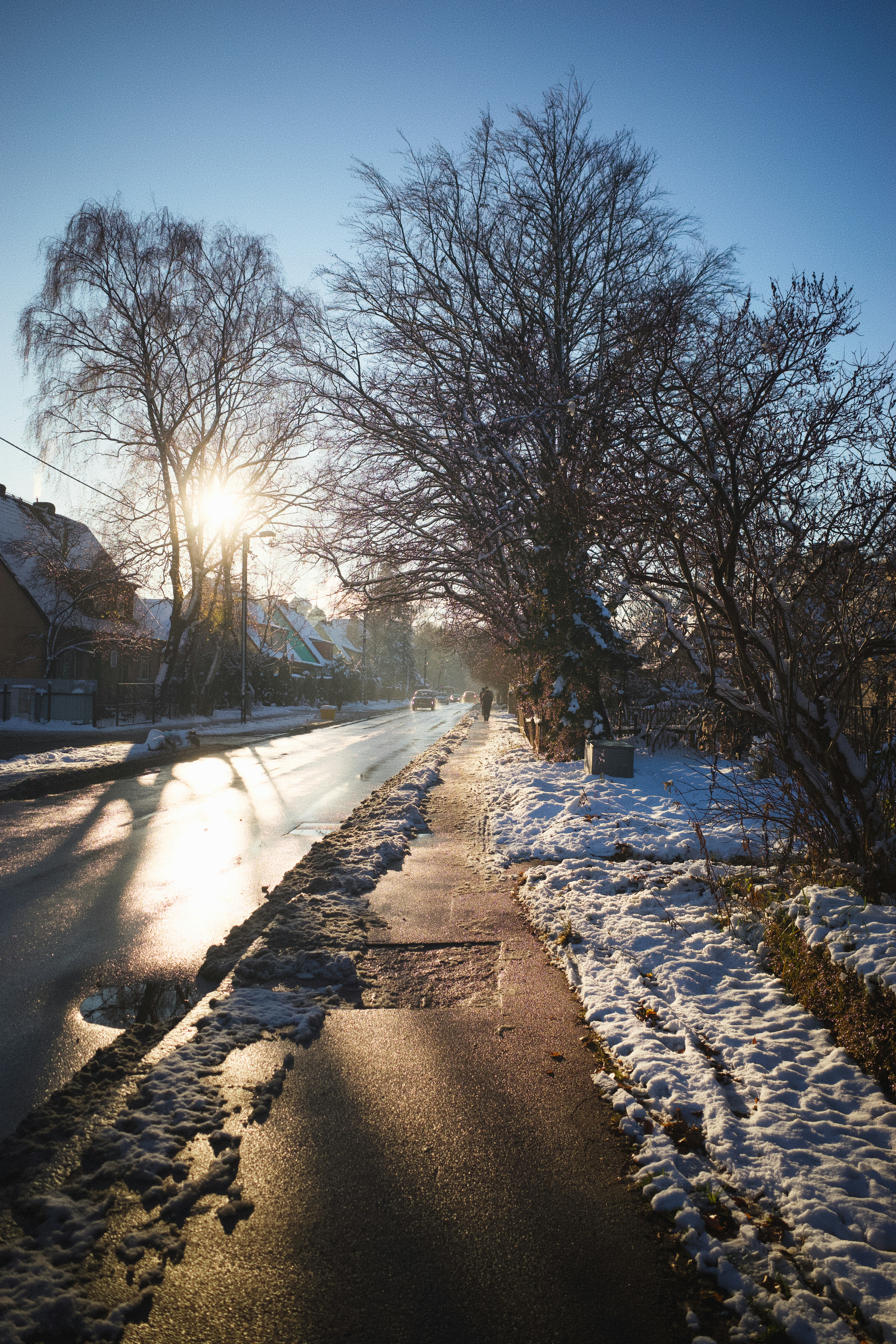 Sunlit Street in Winter: Snow-Cuffed Sidewalk and Sculpted Shadows