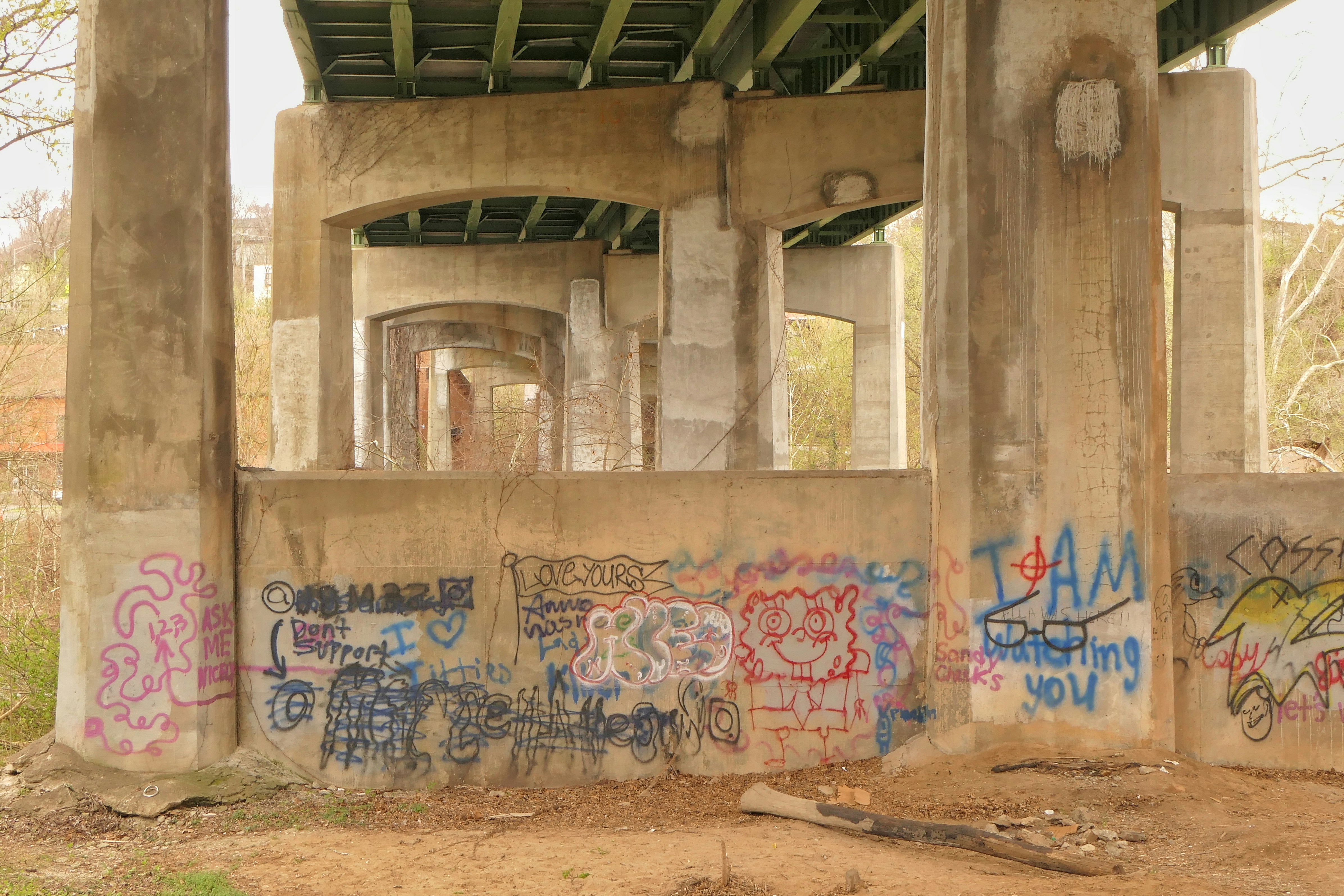 graffiti covered concrete below highway
