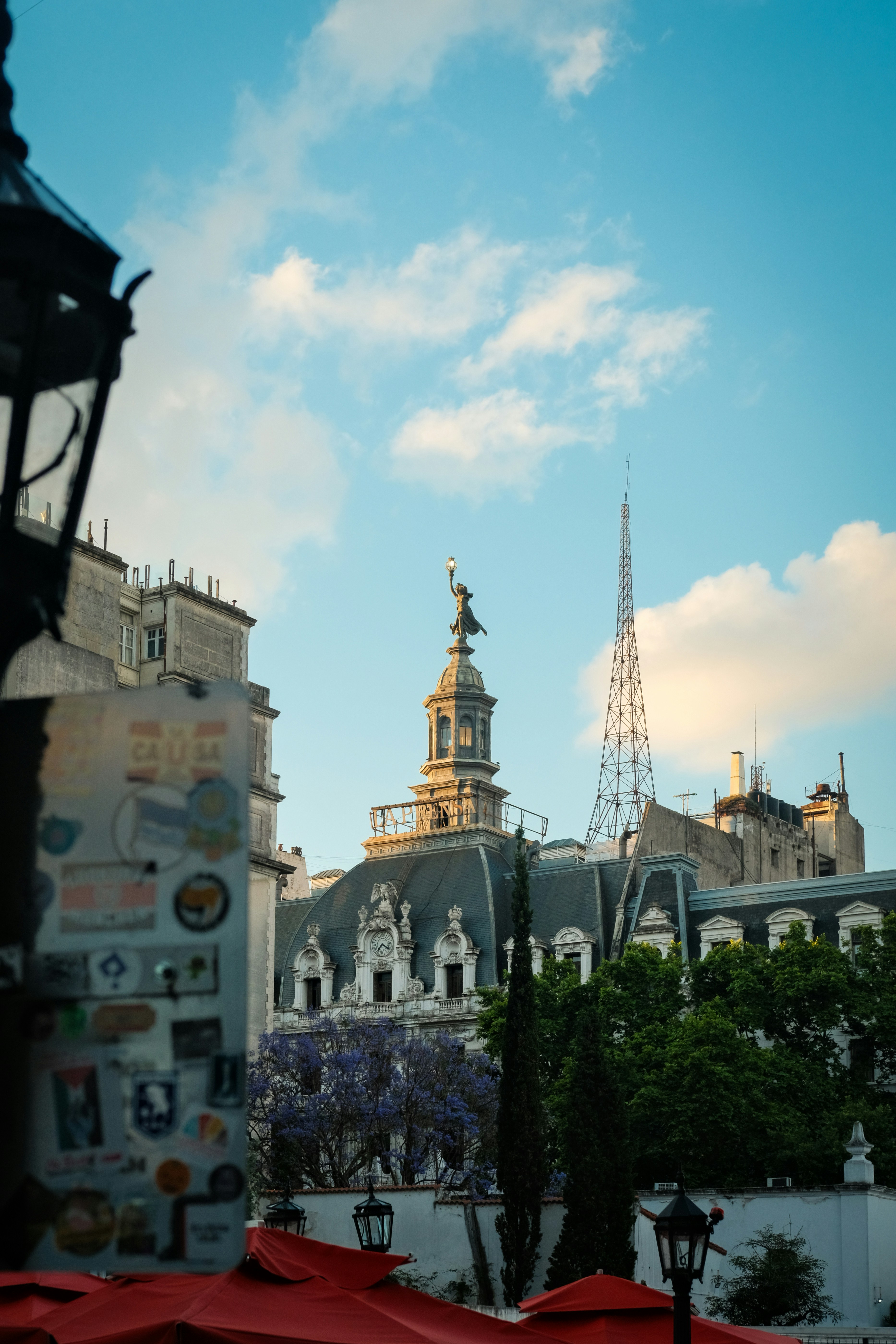 Golden statue crowning a Parisian skyline beneath a blue sky