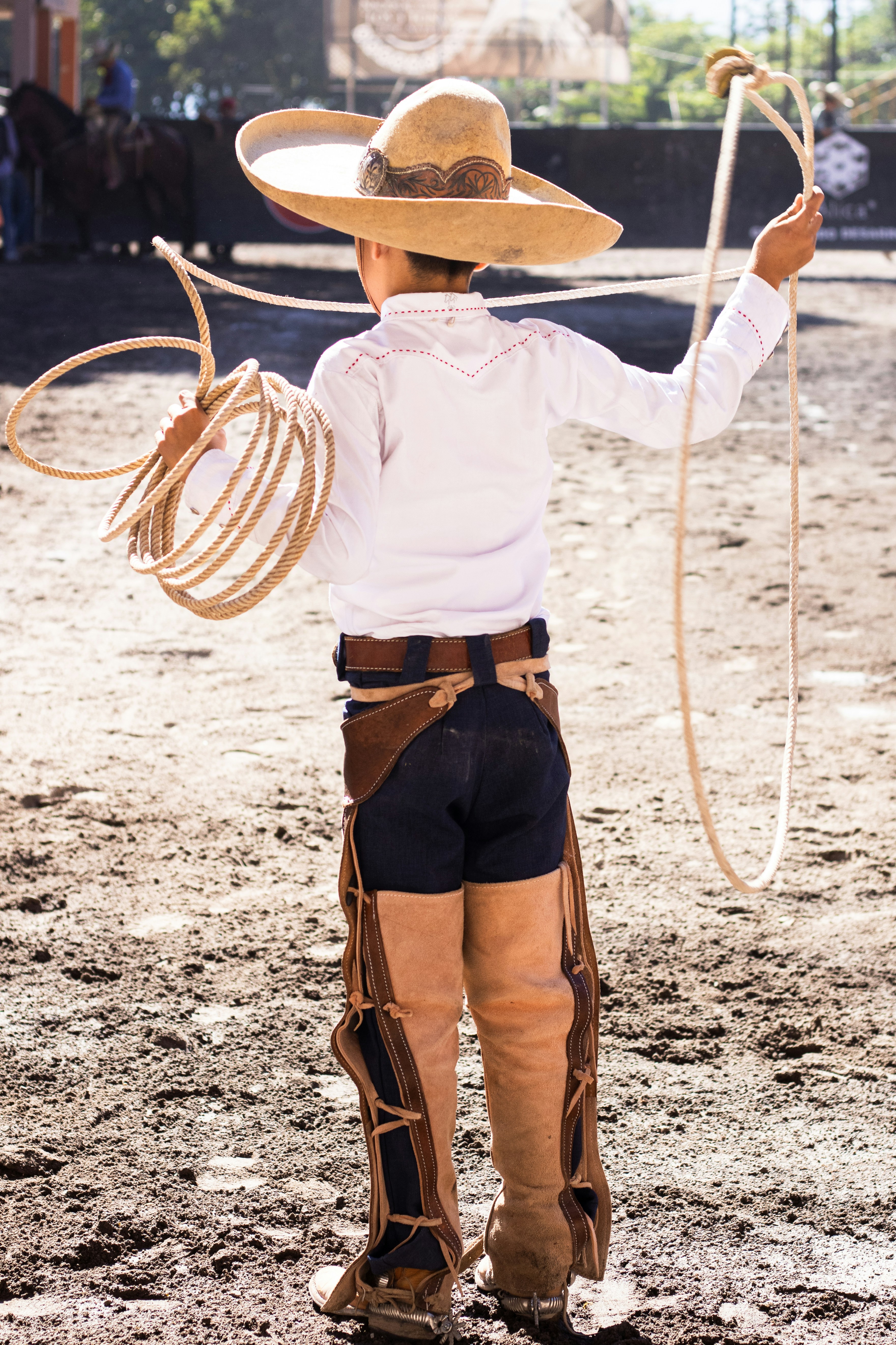 Cowboy Child in White Shirt: Lasso Spirals in a Dusty Arena