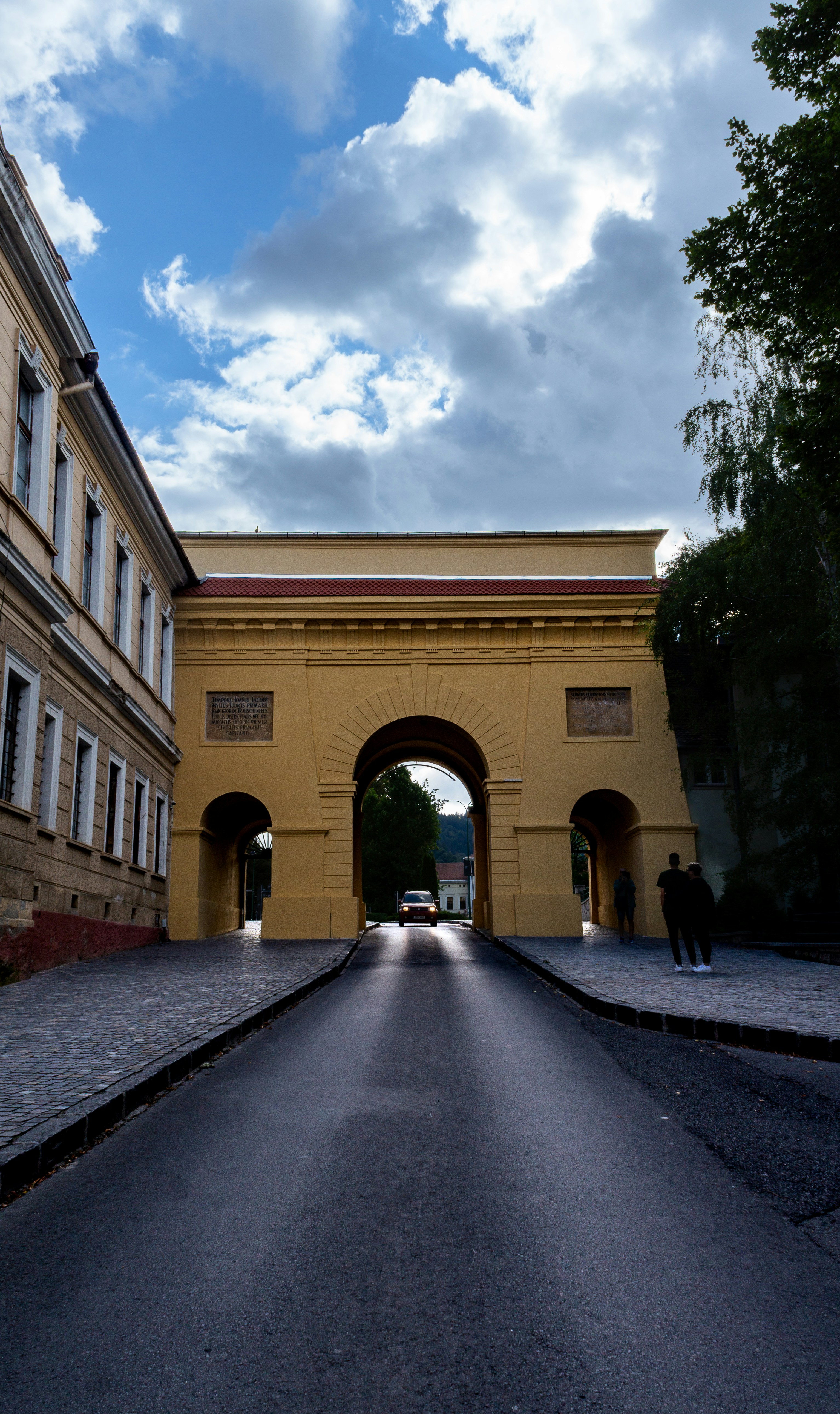 Gateway to the City: A Sunlit Arch Framed by Approaching Road