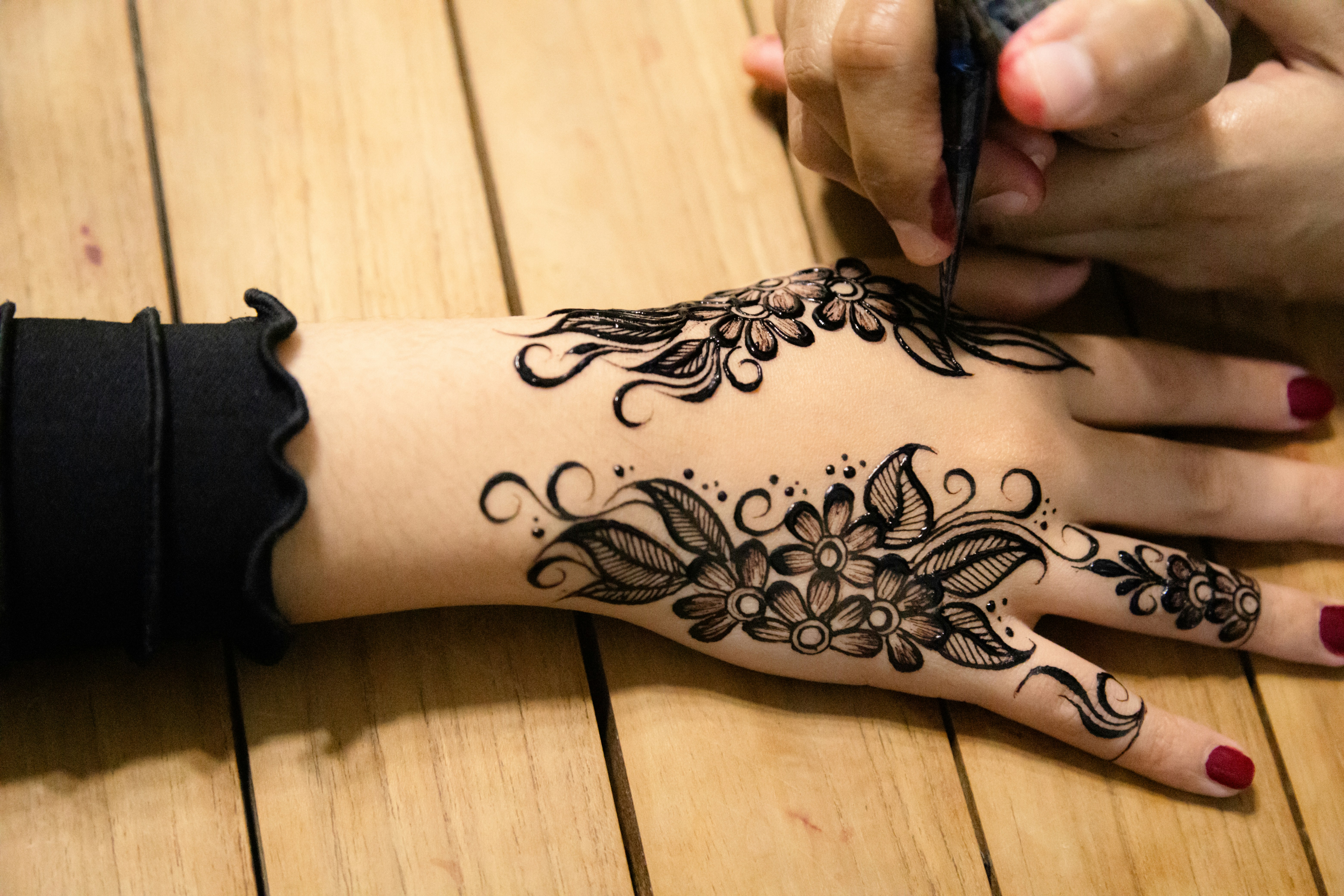 Intricate Henna Hand: Floral Patterns Traced Across a Resting Arm