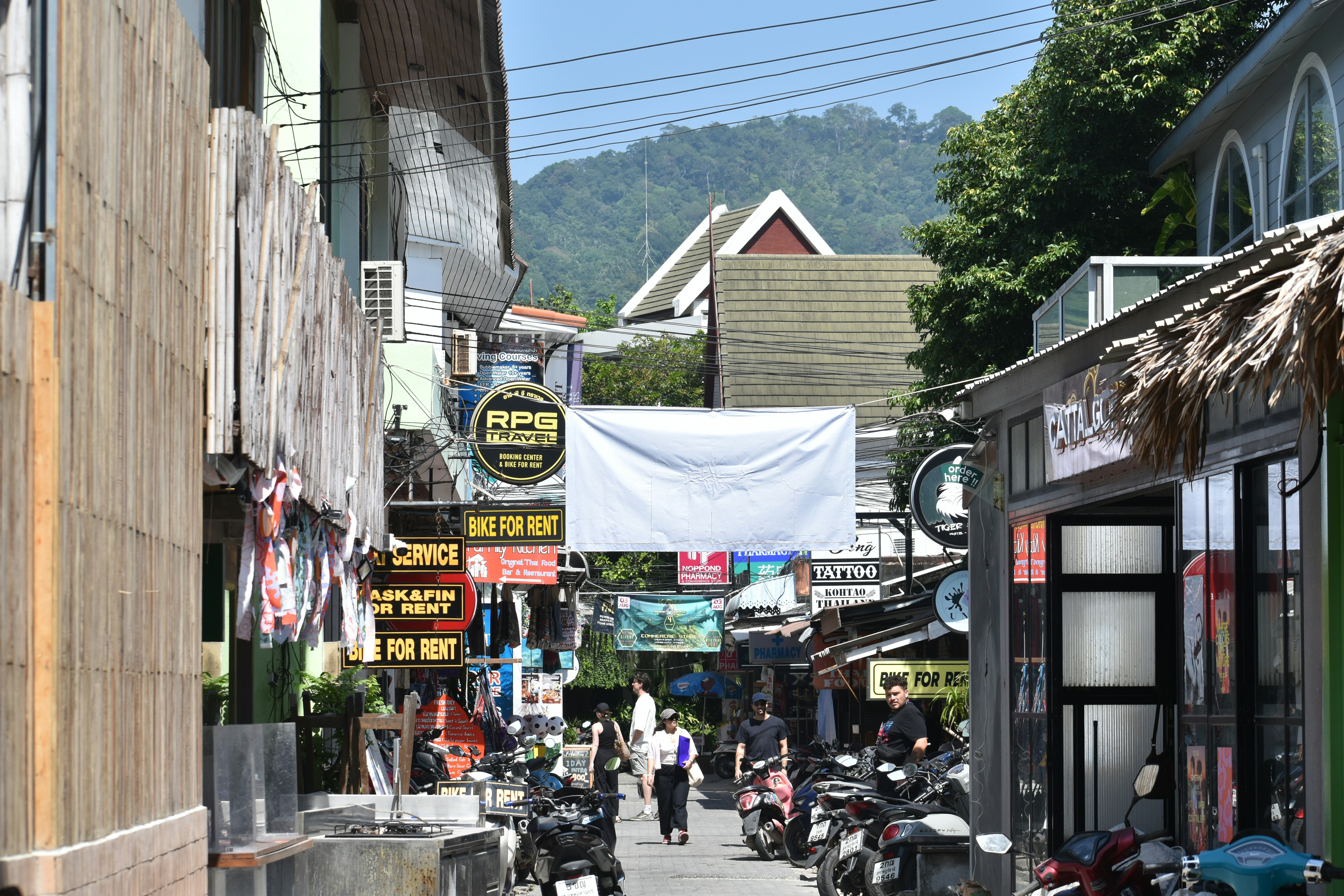 Bustling Street Market Corridor Beneath a Bannered Sky