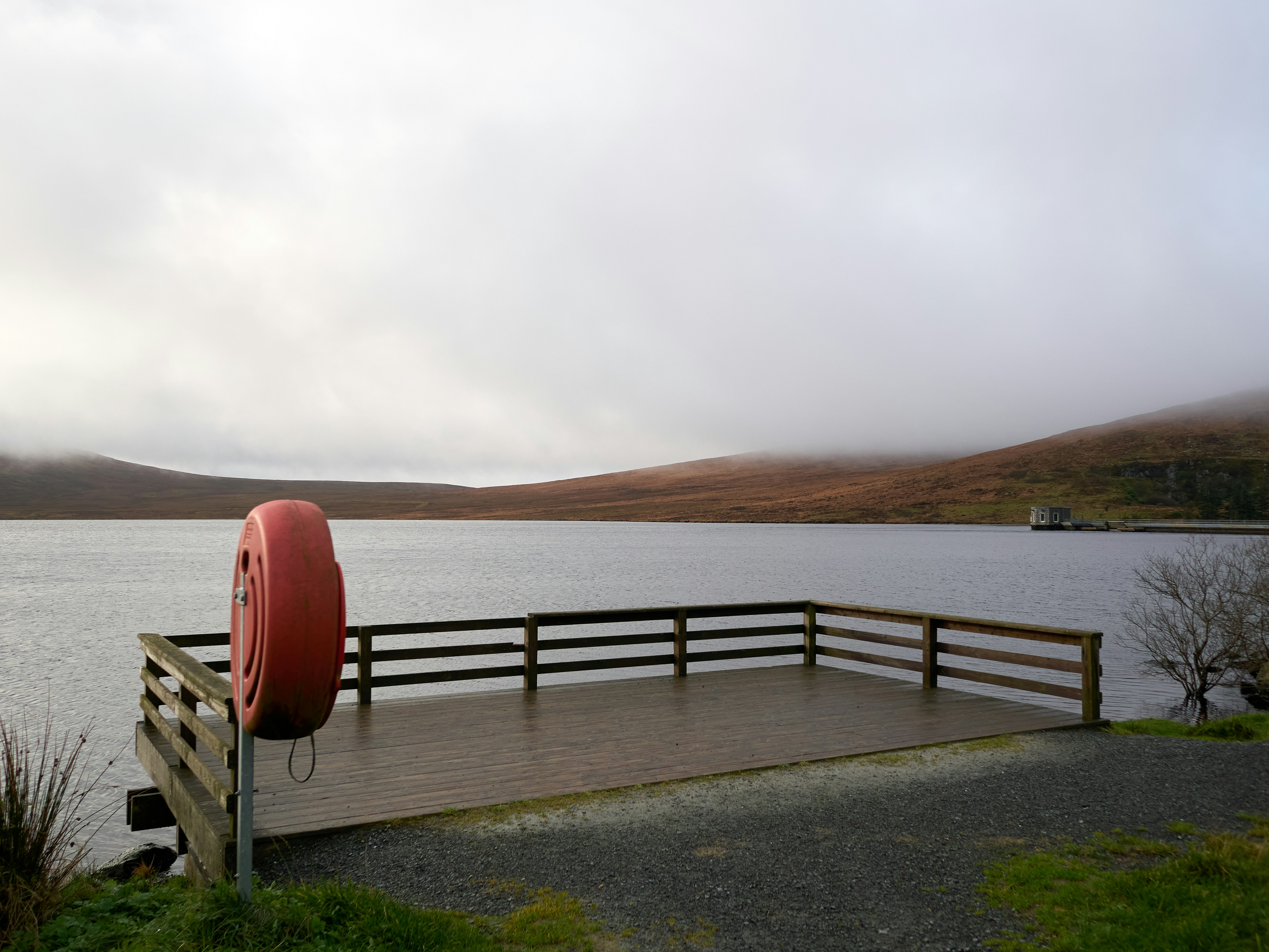 Red Life Ring Overlooking a Quiet Lake on a Misty Moor