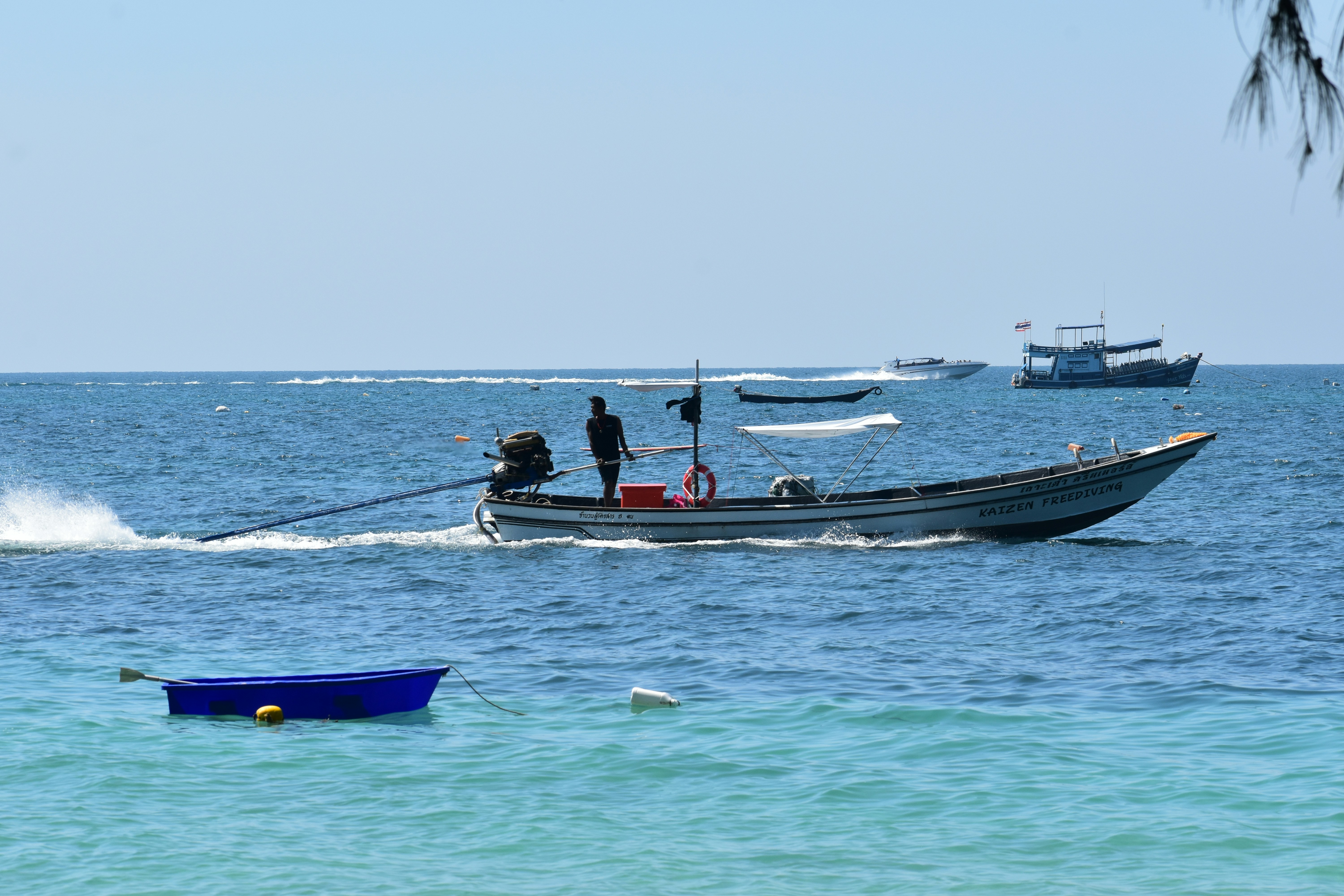Coastal Workboat skims the turquoise shore under a calm horizon