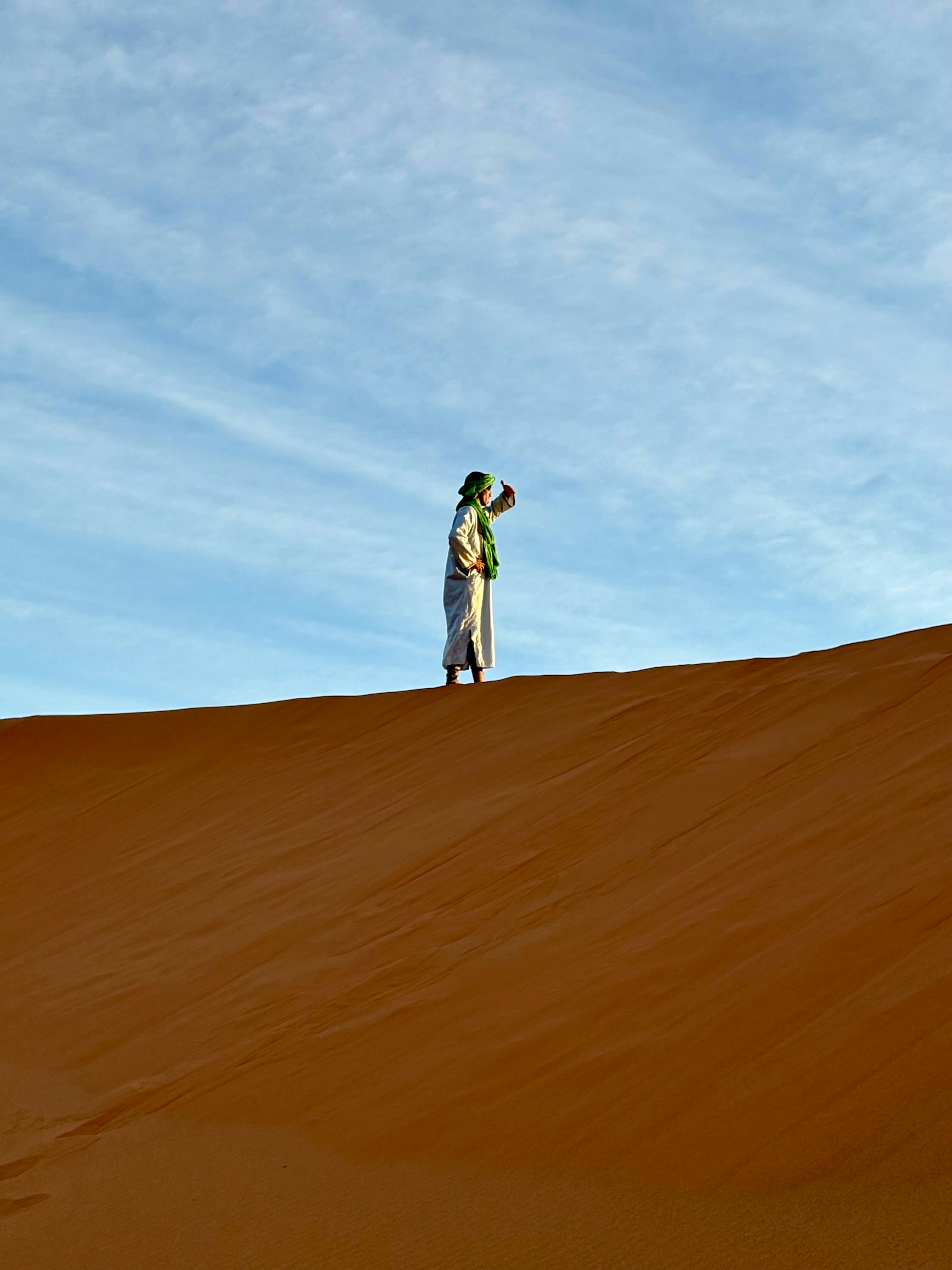 Desert Figure at the Crest: A Lone Traveler on the Dune