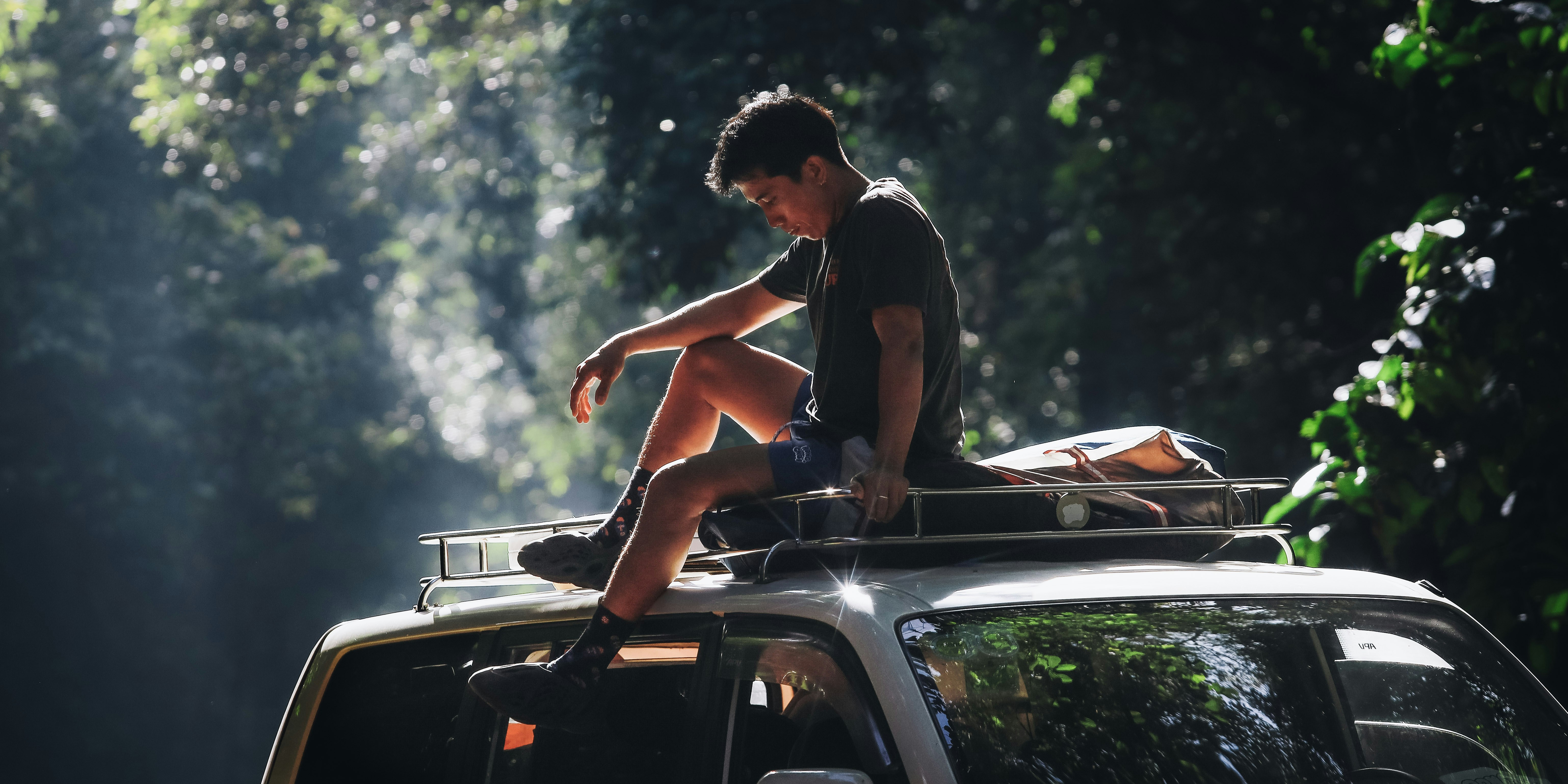Rooftop Pause: A Solo Traveler Resting Above the Forest Green