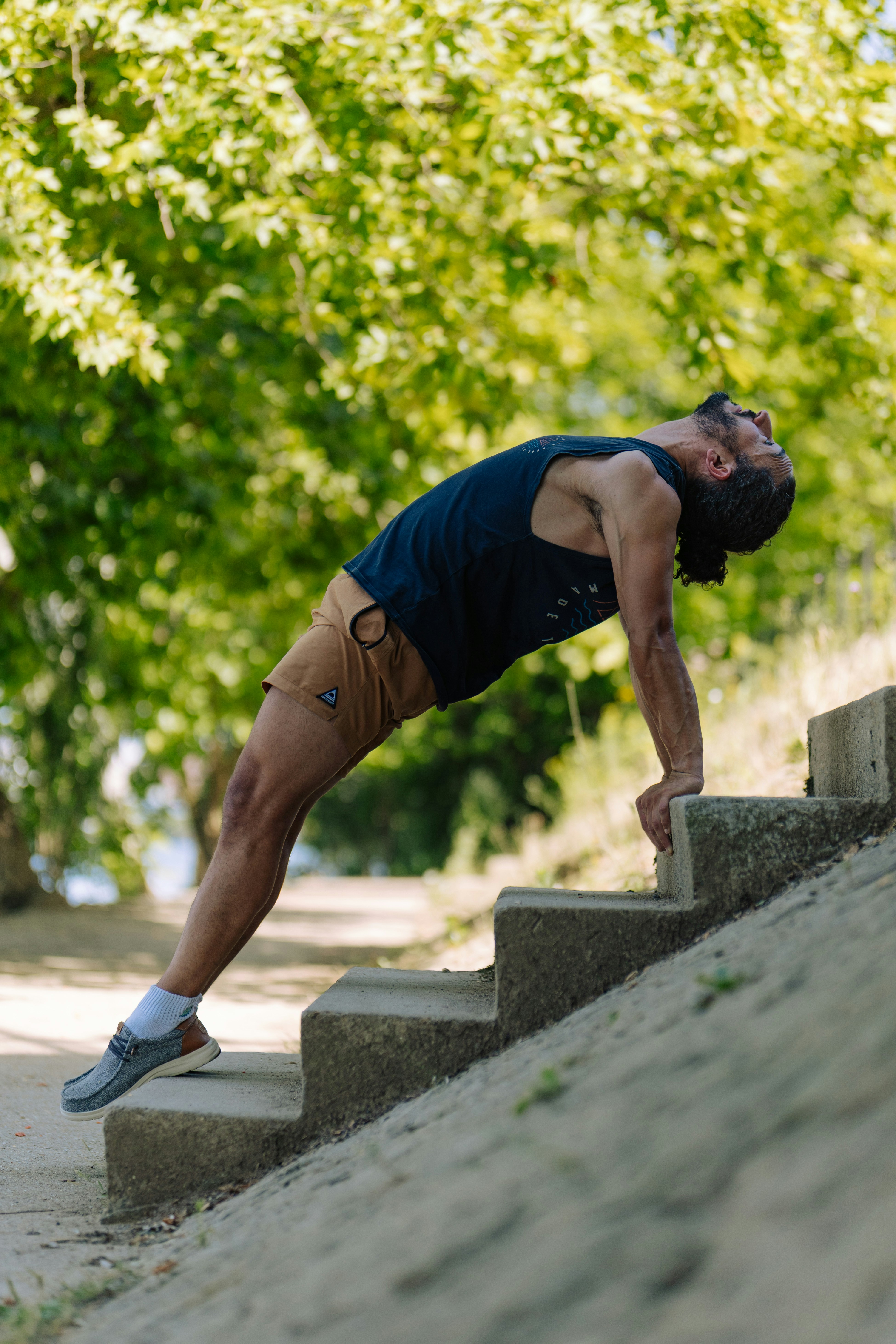 Arched Back, Steady Gaze: A climber pauses mid-stretch on sunlit stairs