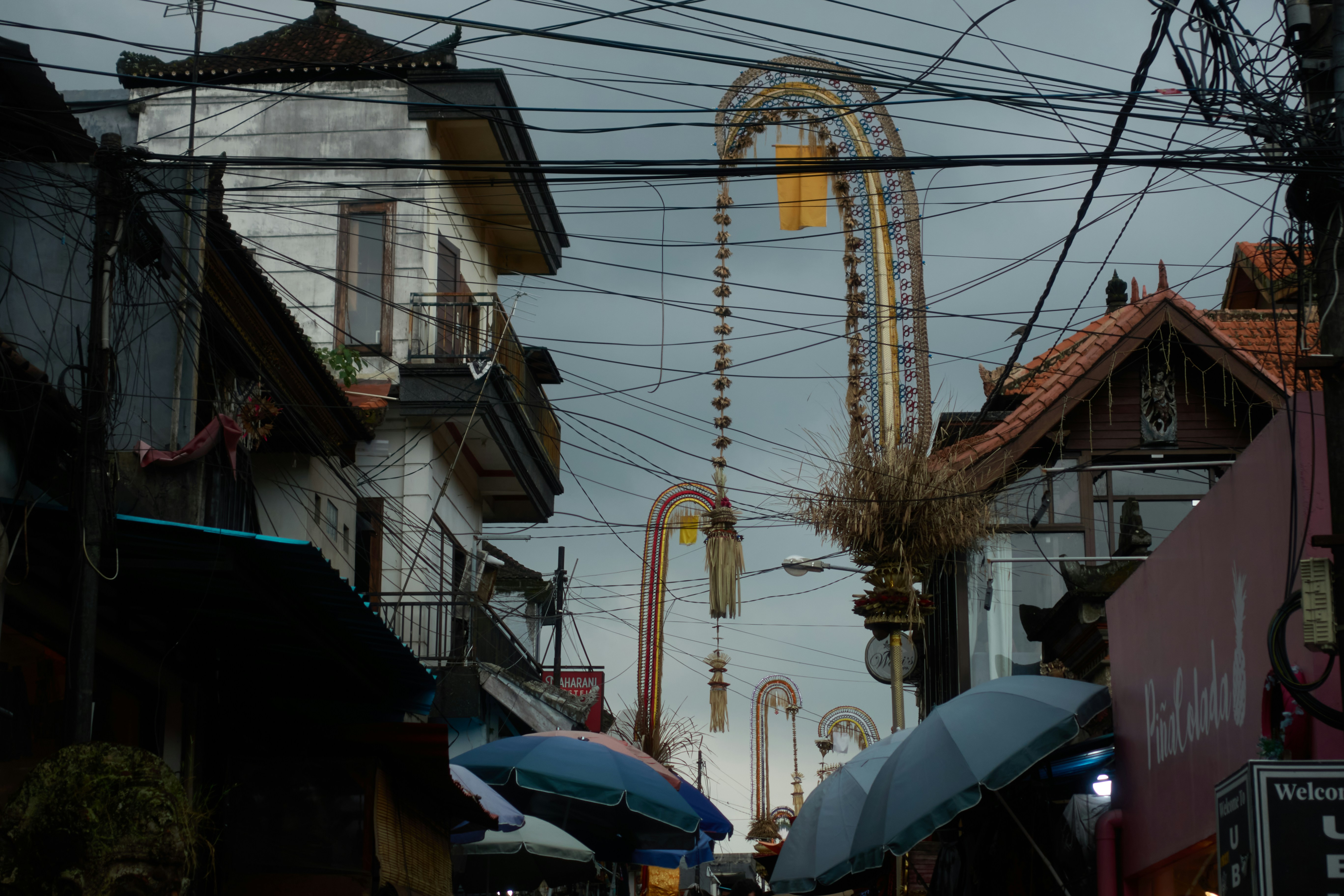 Street festival arches rise above a quiet market street on a cloudy day