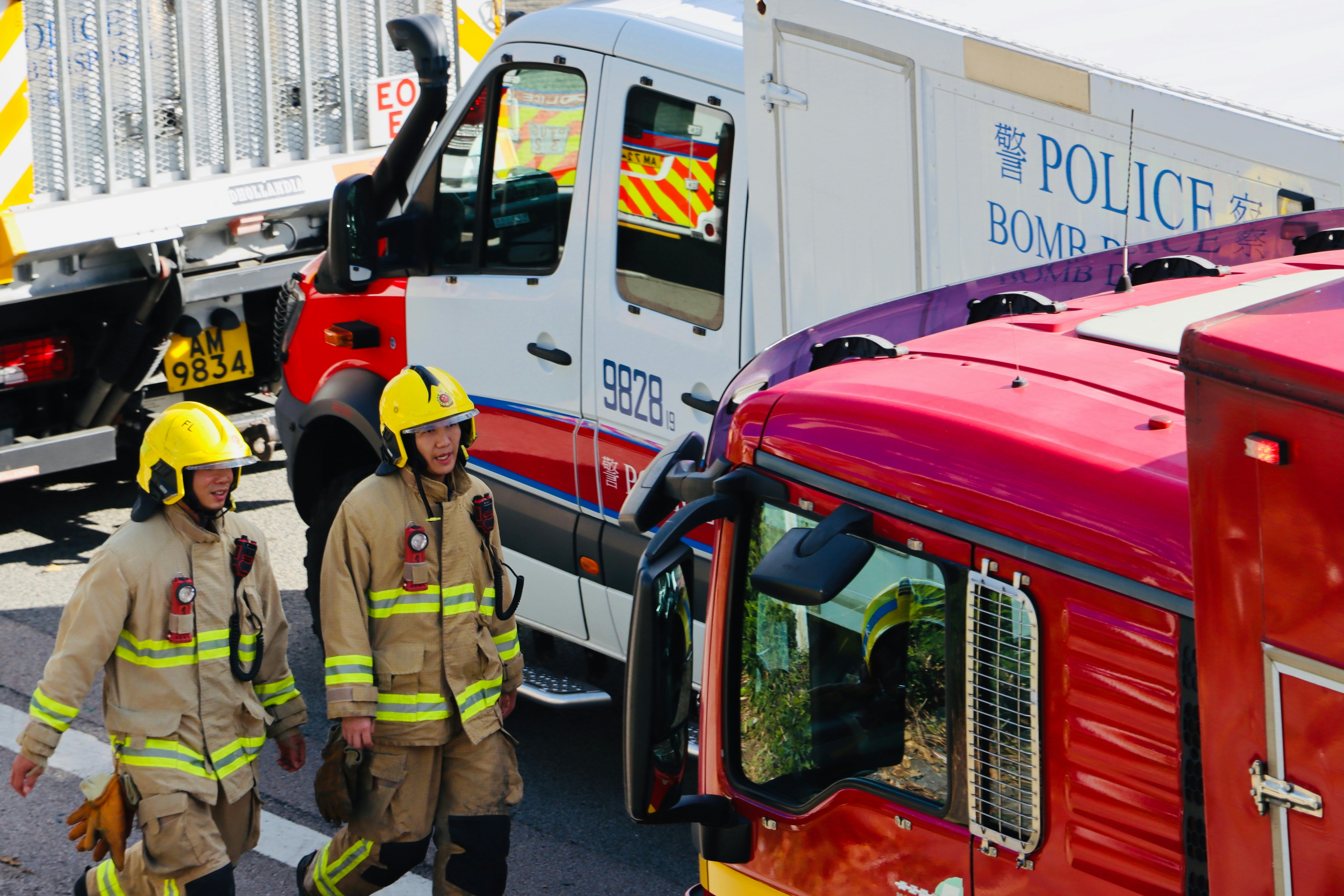 Courage on the frontline: firefighters step from the scene beside a police tow unit
