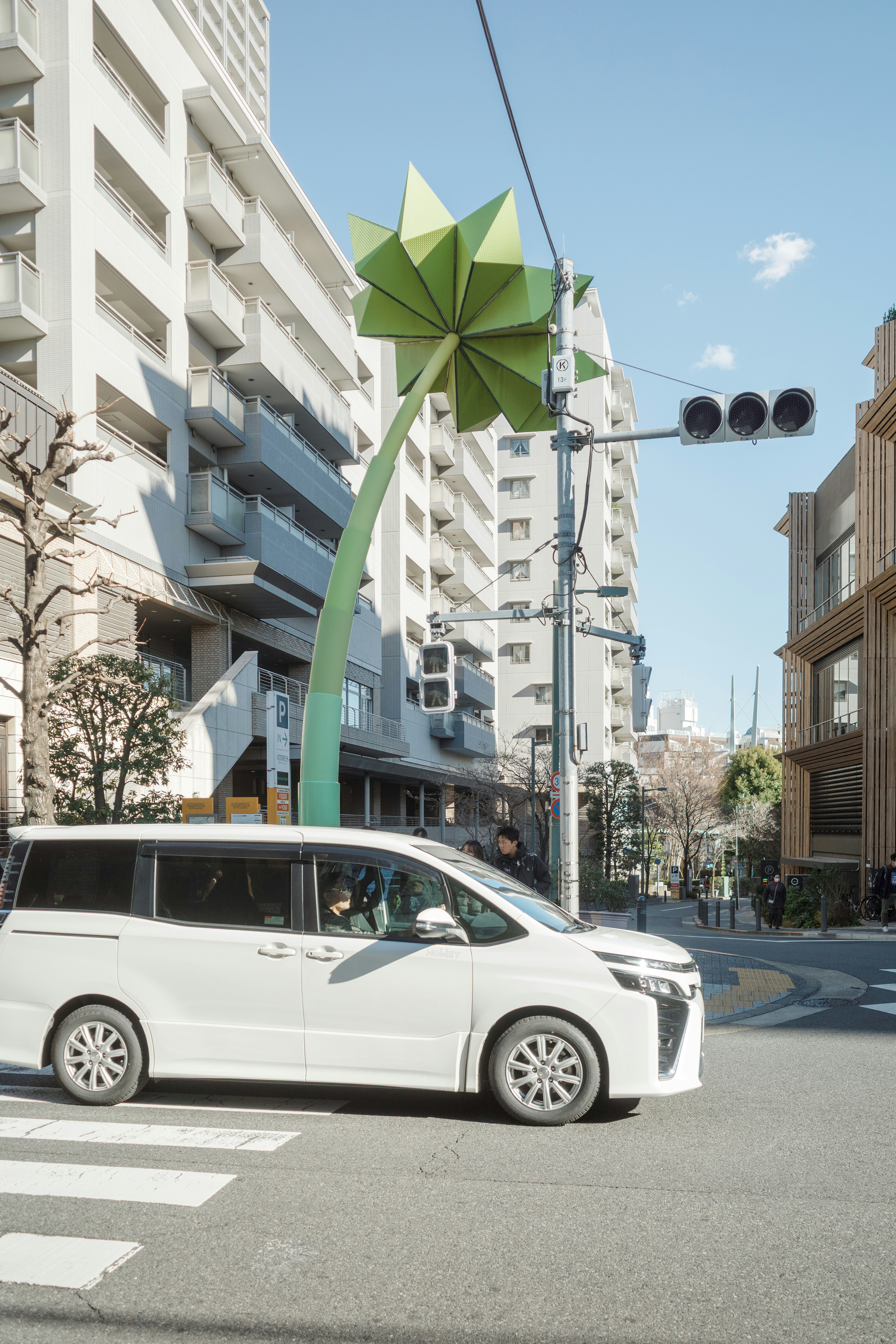 Urban Sculpture Under Clear Sky: A Green Star Arches Over a Quiet Street