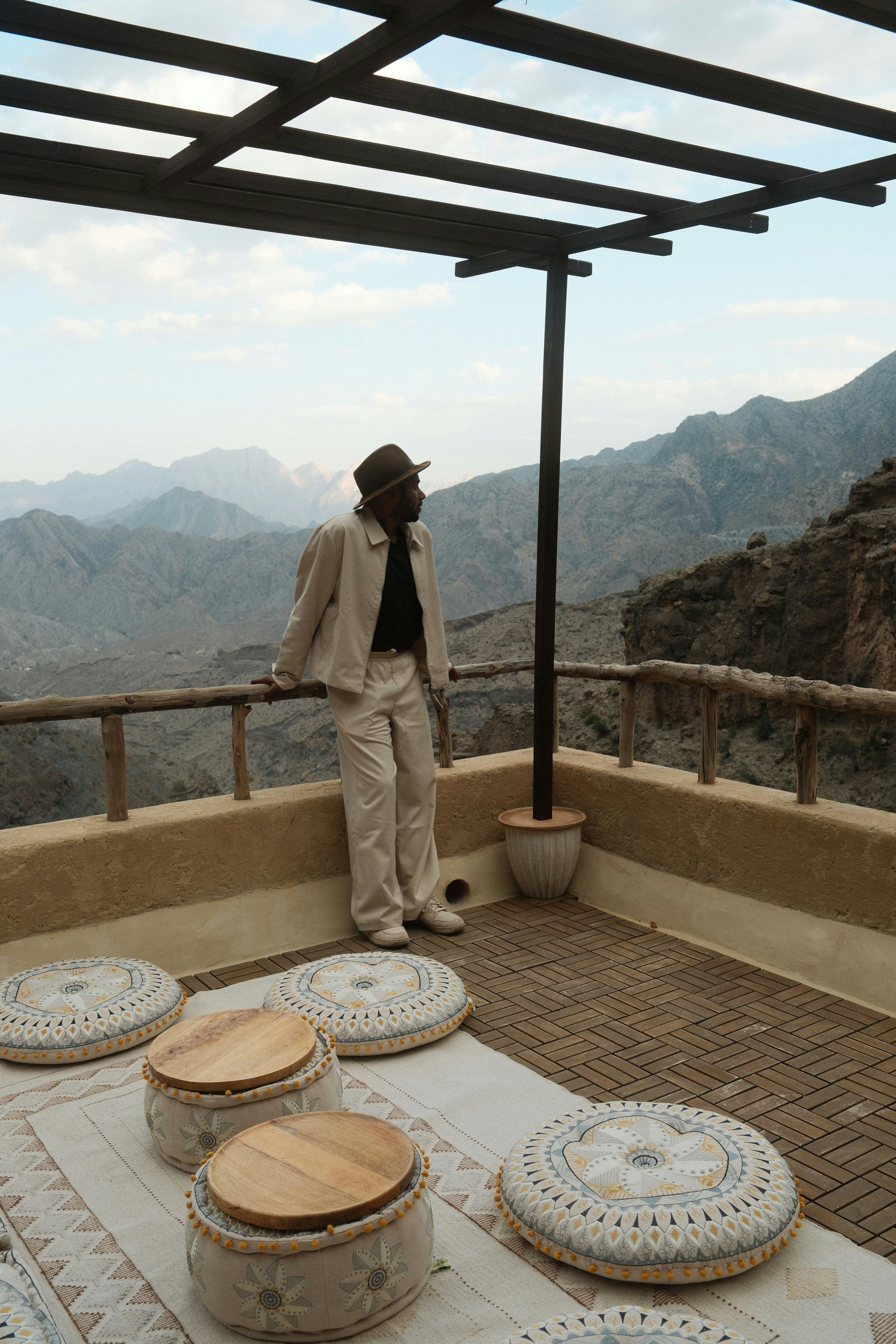  vantage at the cliffside terrace with a man in light tones looking toward distant mountains