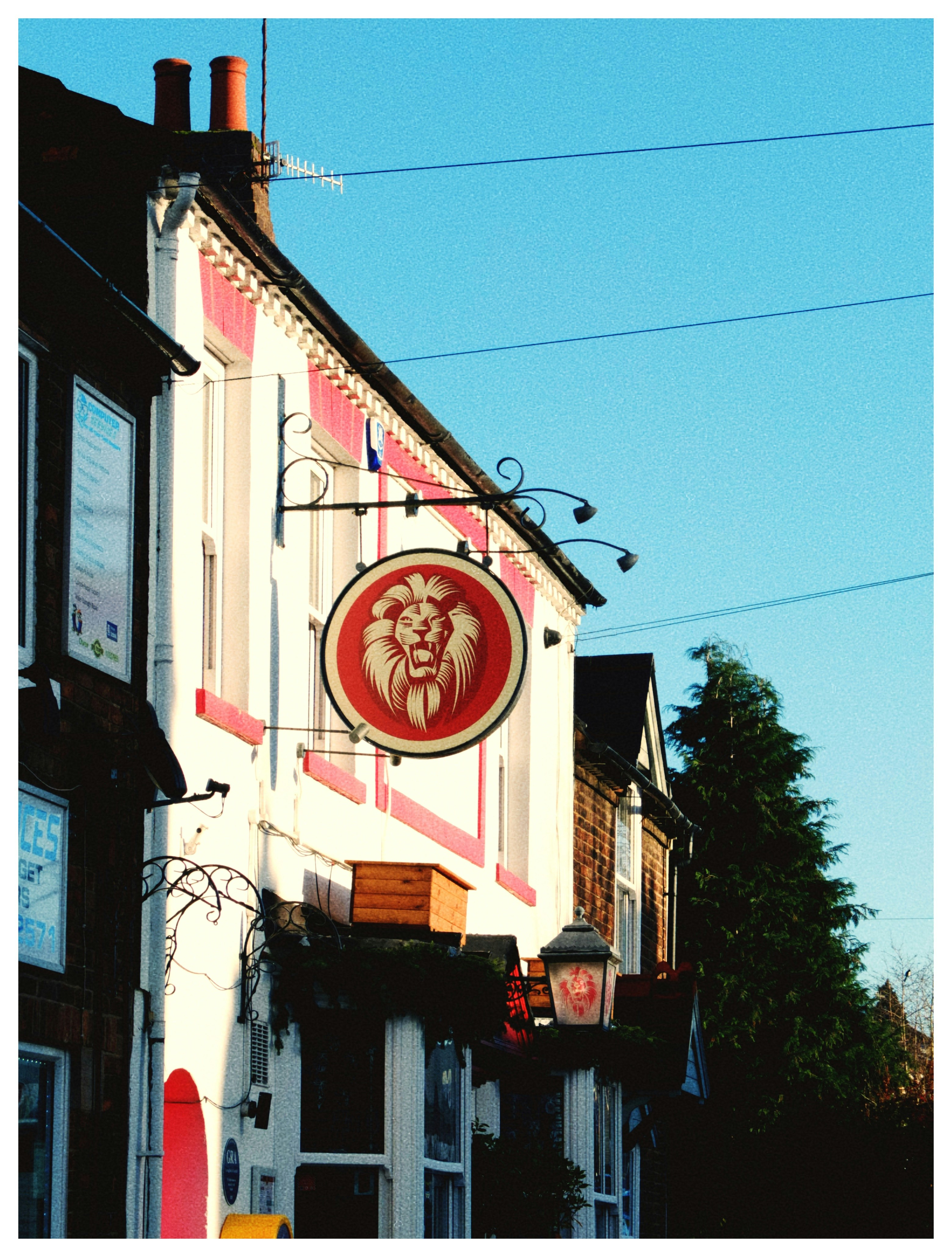 Lion Sign on a Quiet European Storefront Against Clear Sky
