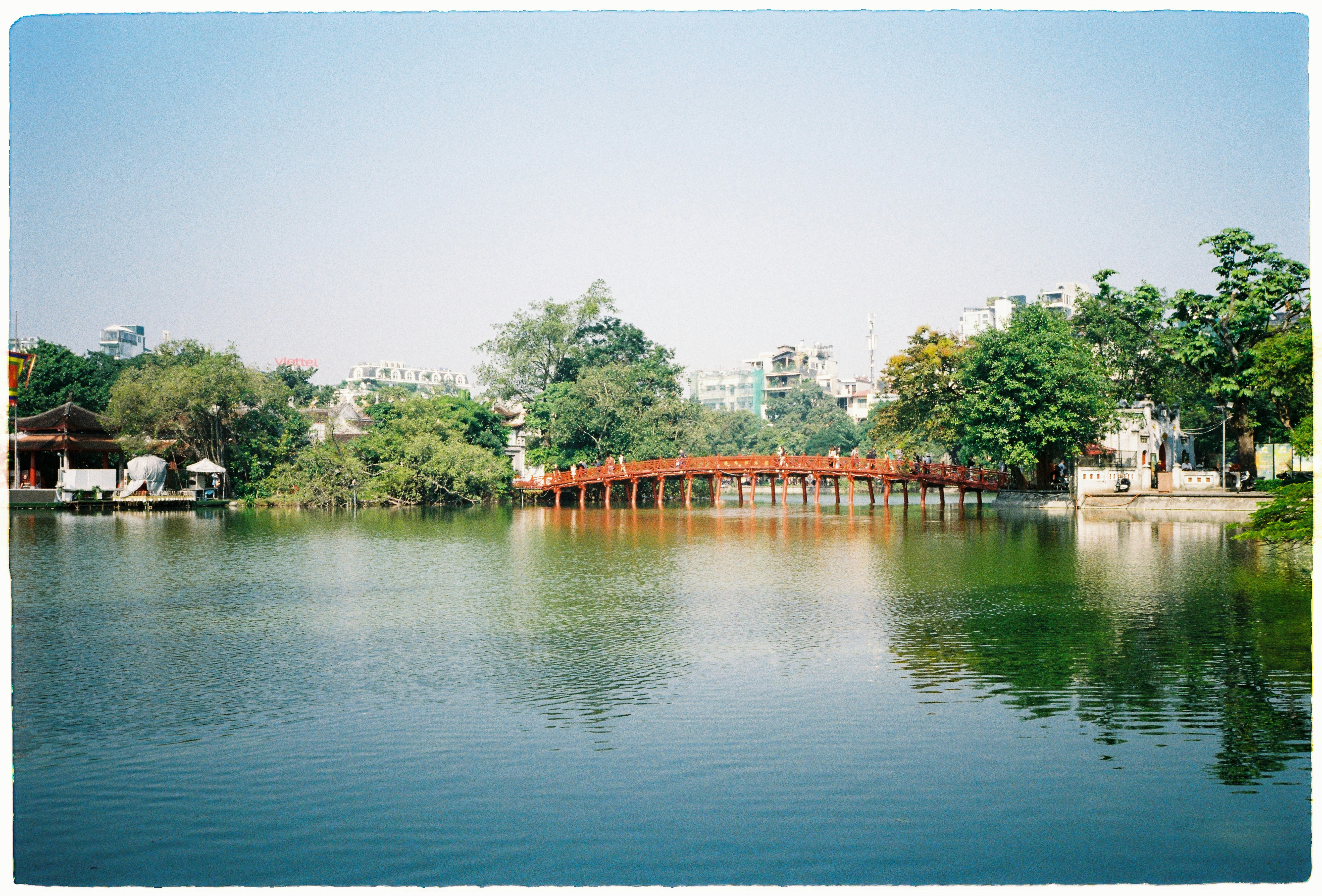 Red bridge over a tranquil lake with trees photo – Free Architecture ...