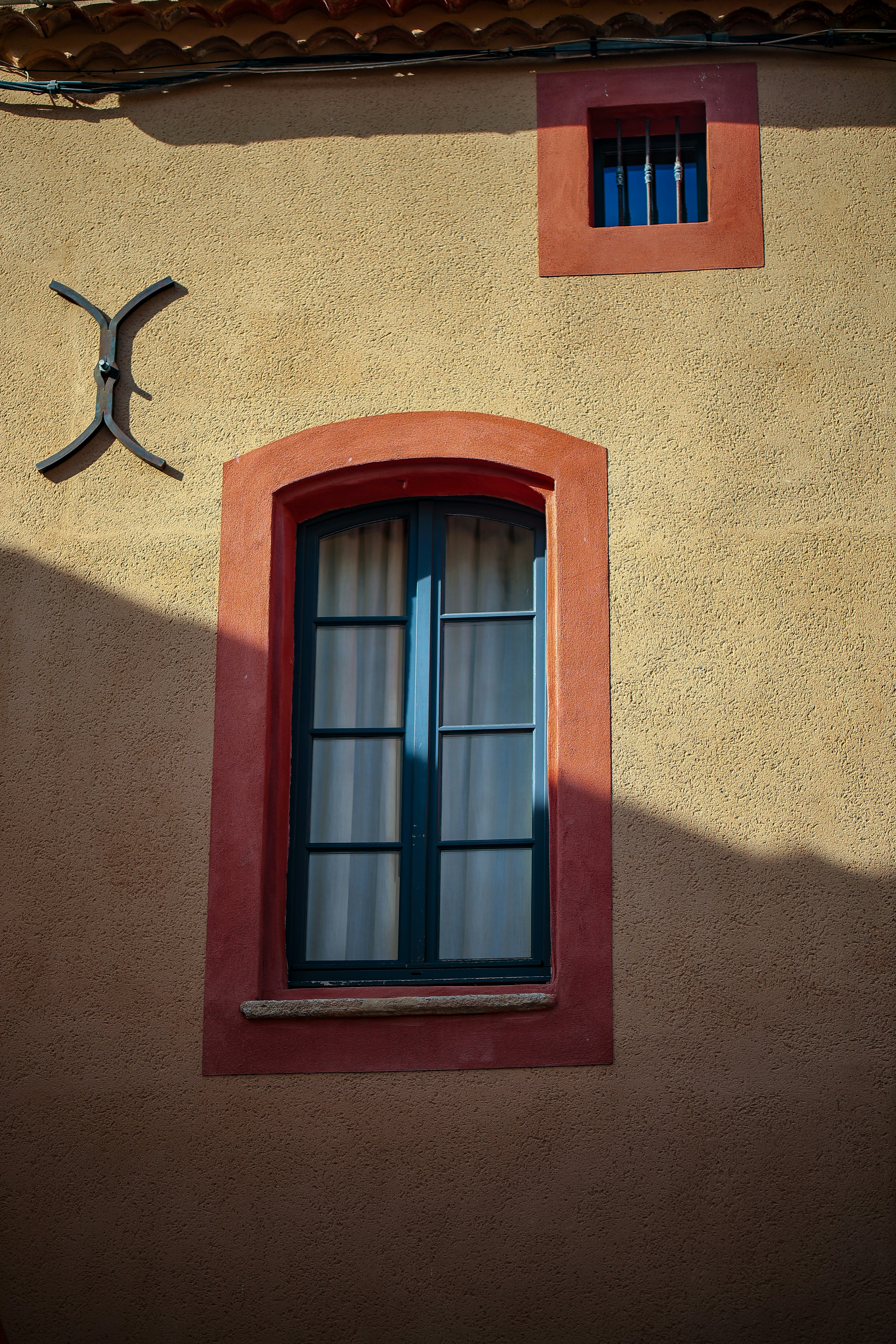 Sunlit Window with Shadowed Exterior: A Mediterranean Wall Study